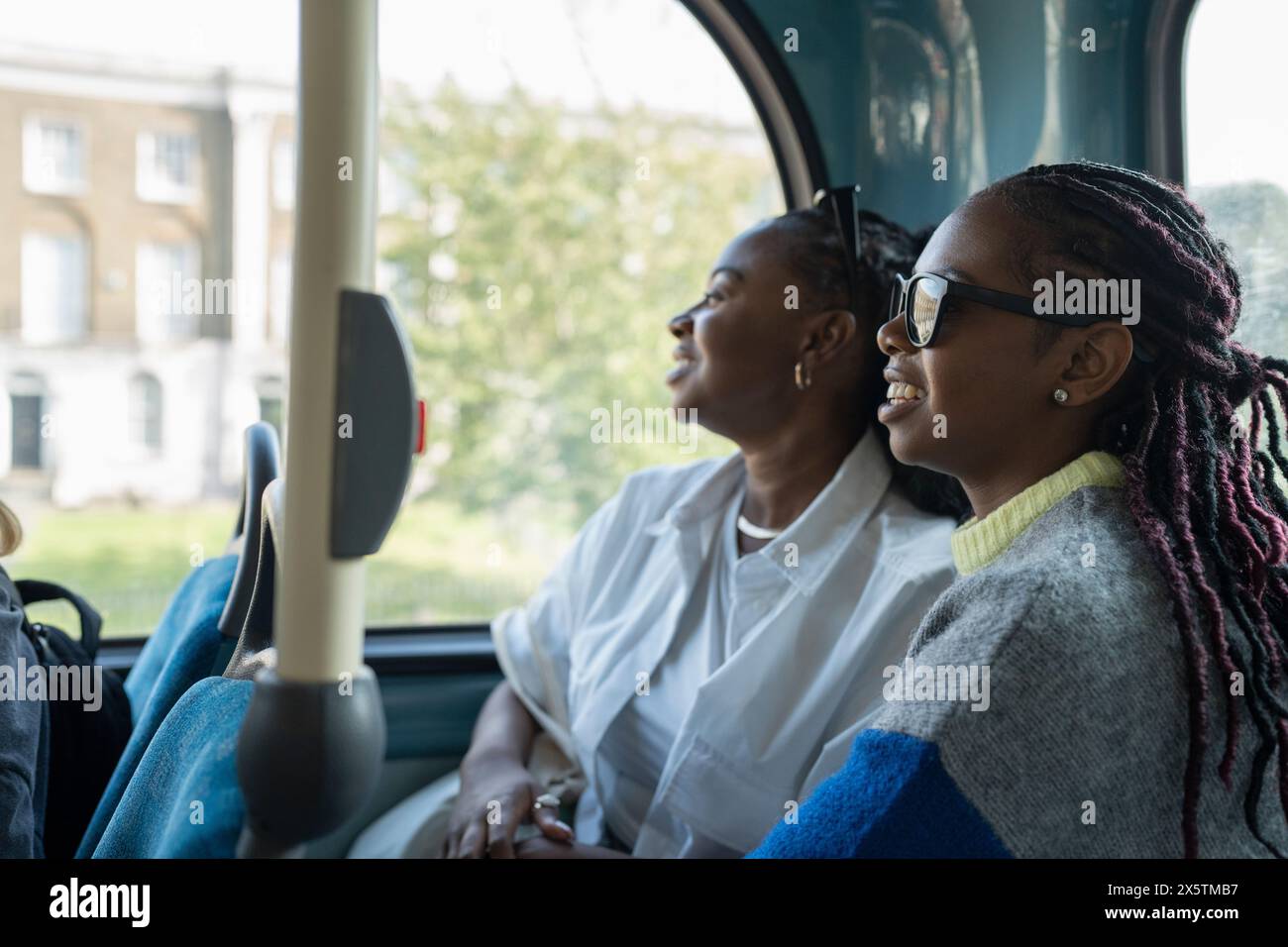 Young female friends riding city bus Stock Photo - Alamy