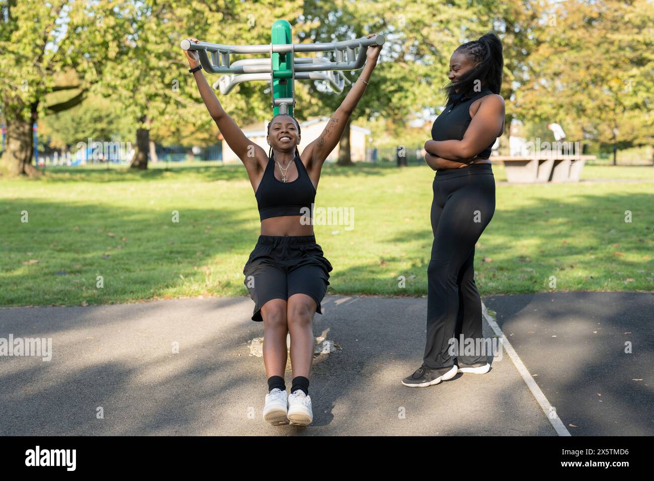 Young female friends working out in outdoor gym Stock Photo - Alamy