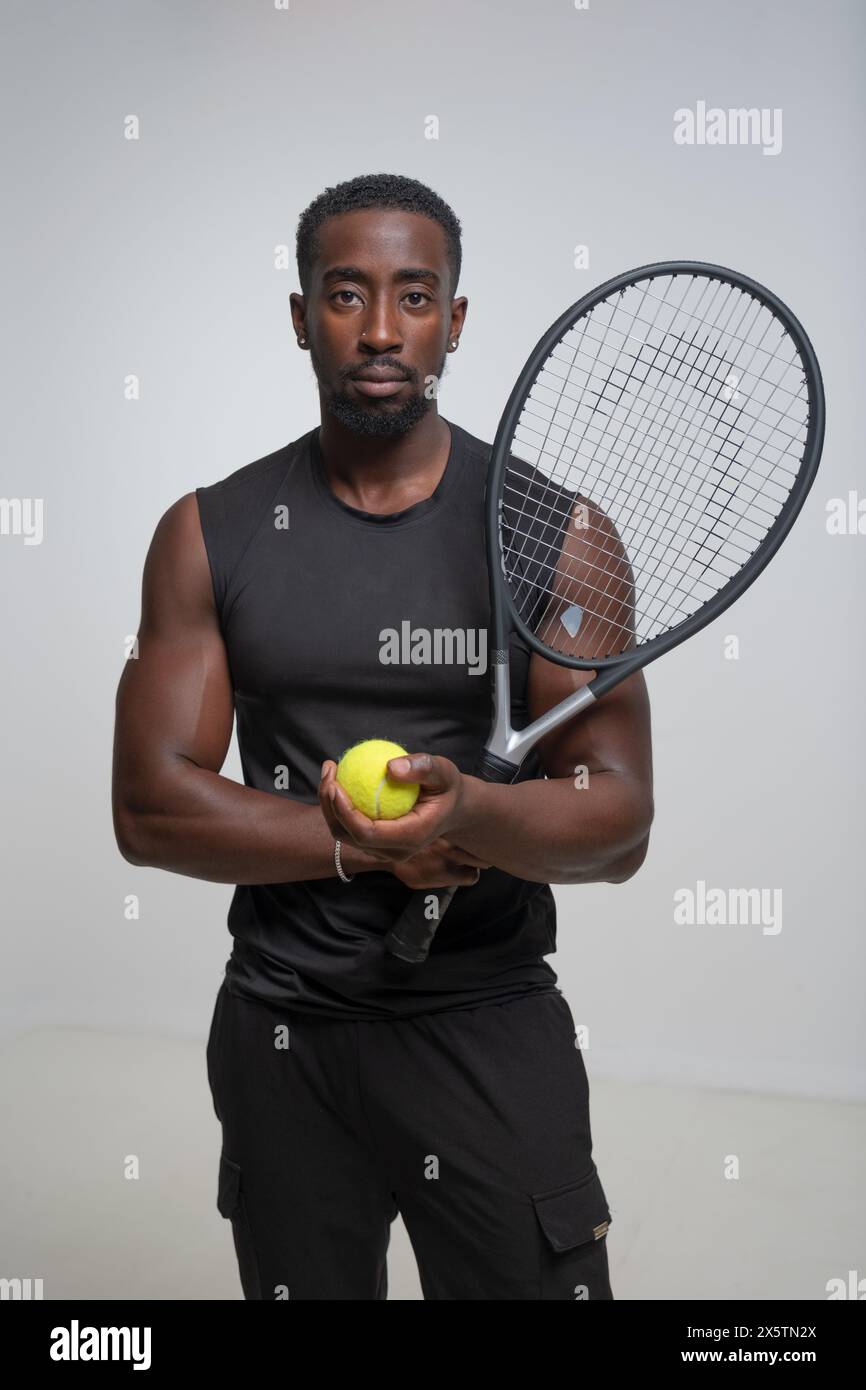 Portrait of man holding tennis ball and racket Stock Photo - Alamy