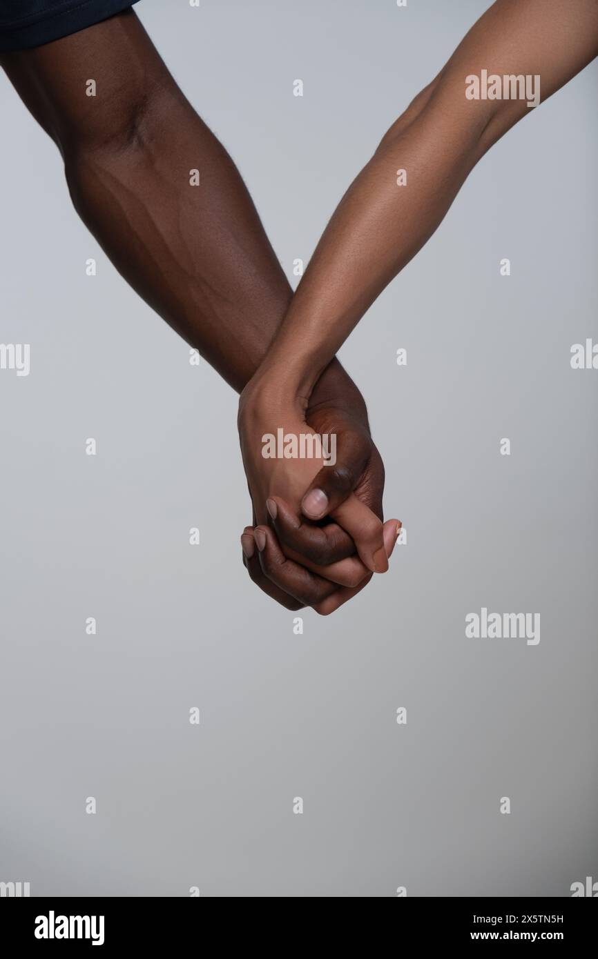 Couple holding hands together Stock Photo - Alamy