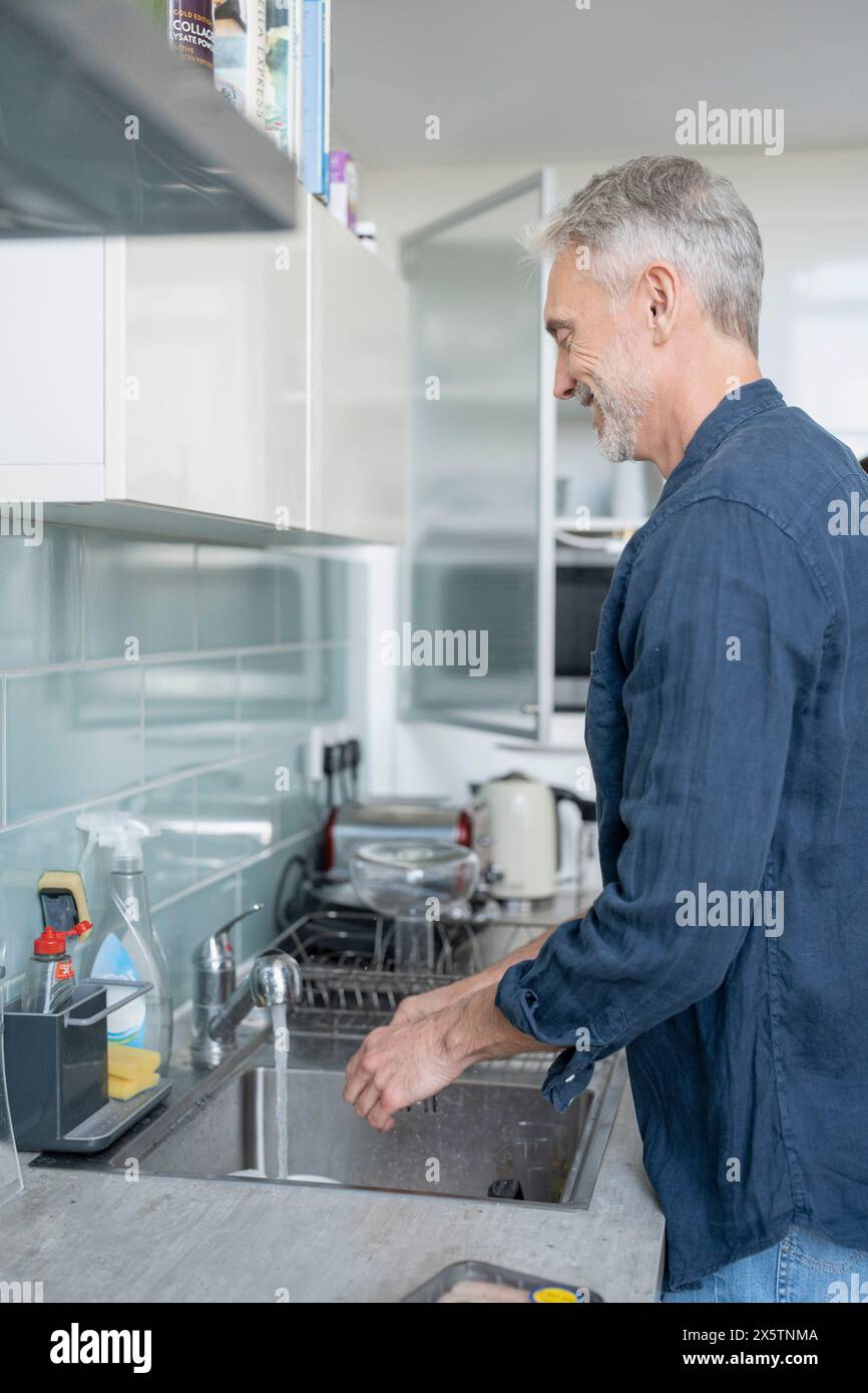 Man washing hands in sink hi-res stock photography and images - Alamy