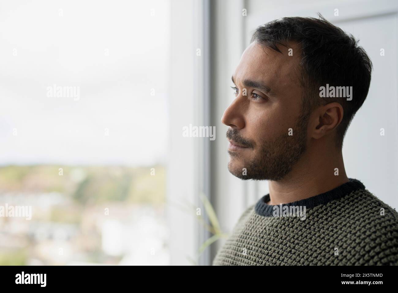 Mature man looking through window Stock Photo - Alamy