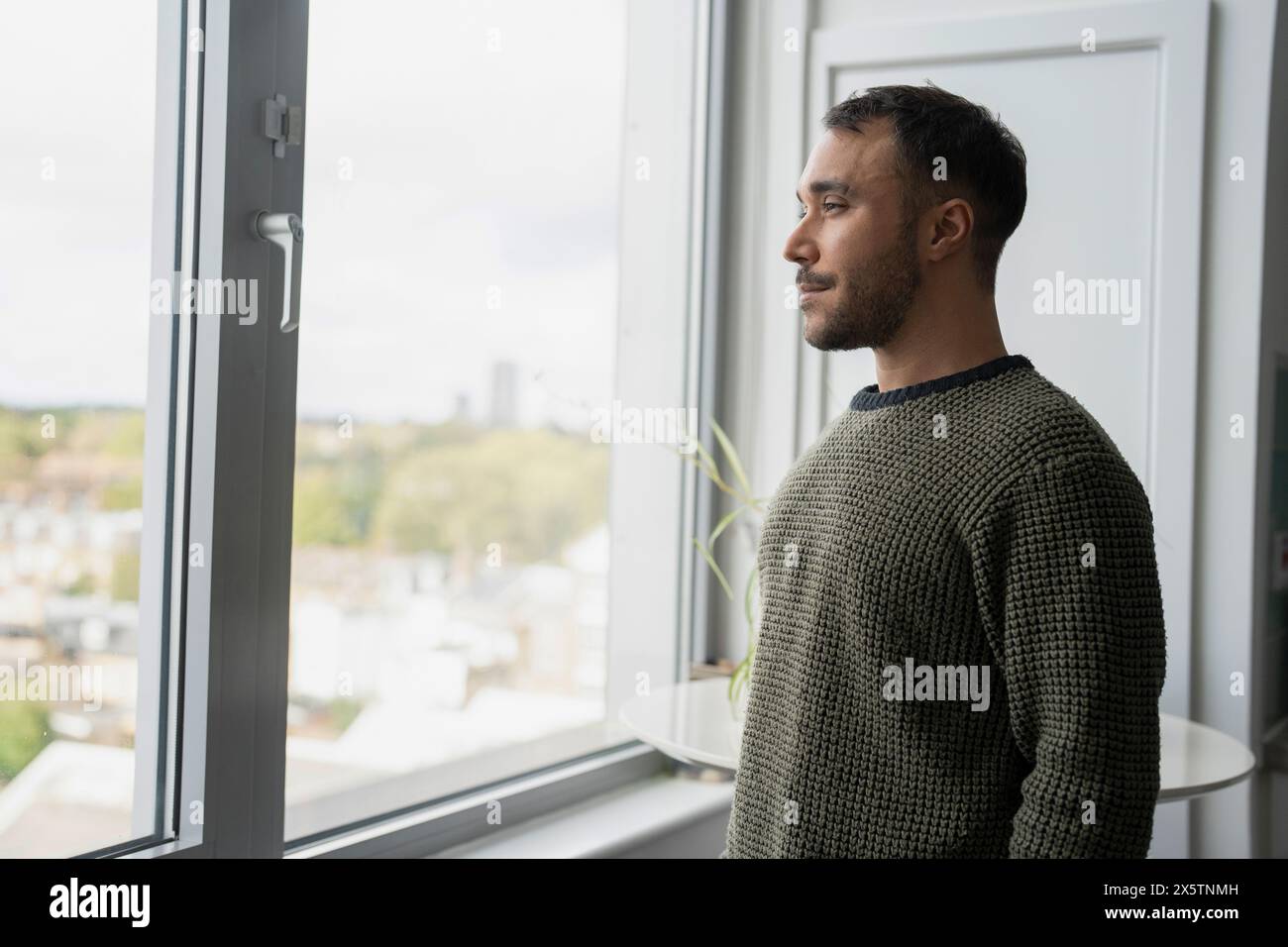 Mature man looking through window Stock Photo - Alamy