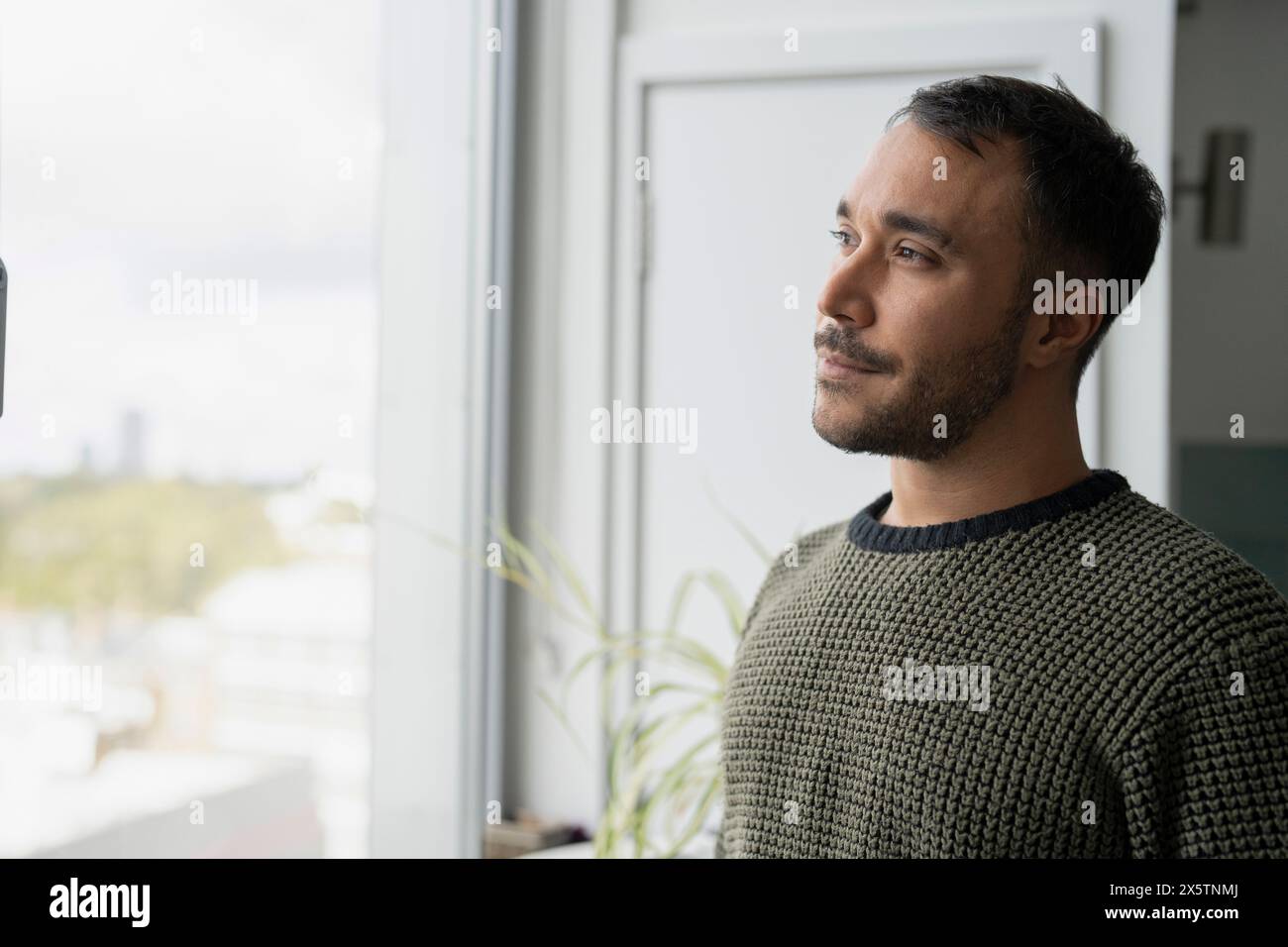 Mature man looking through window Stock Photo - Alamy