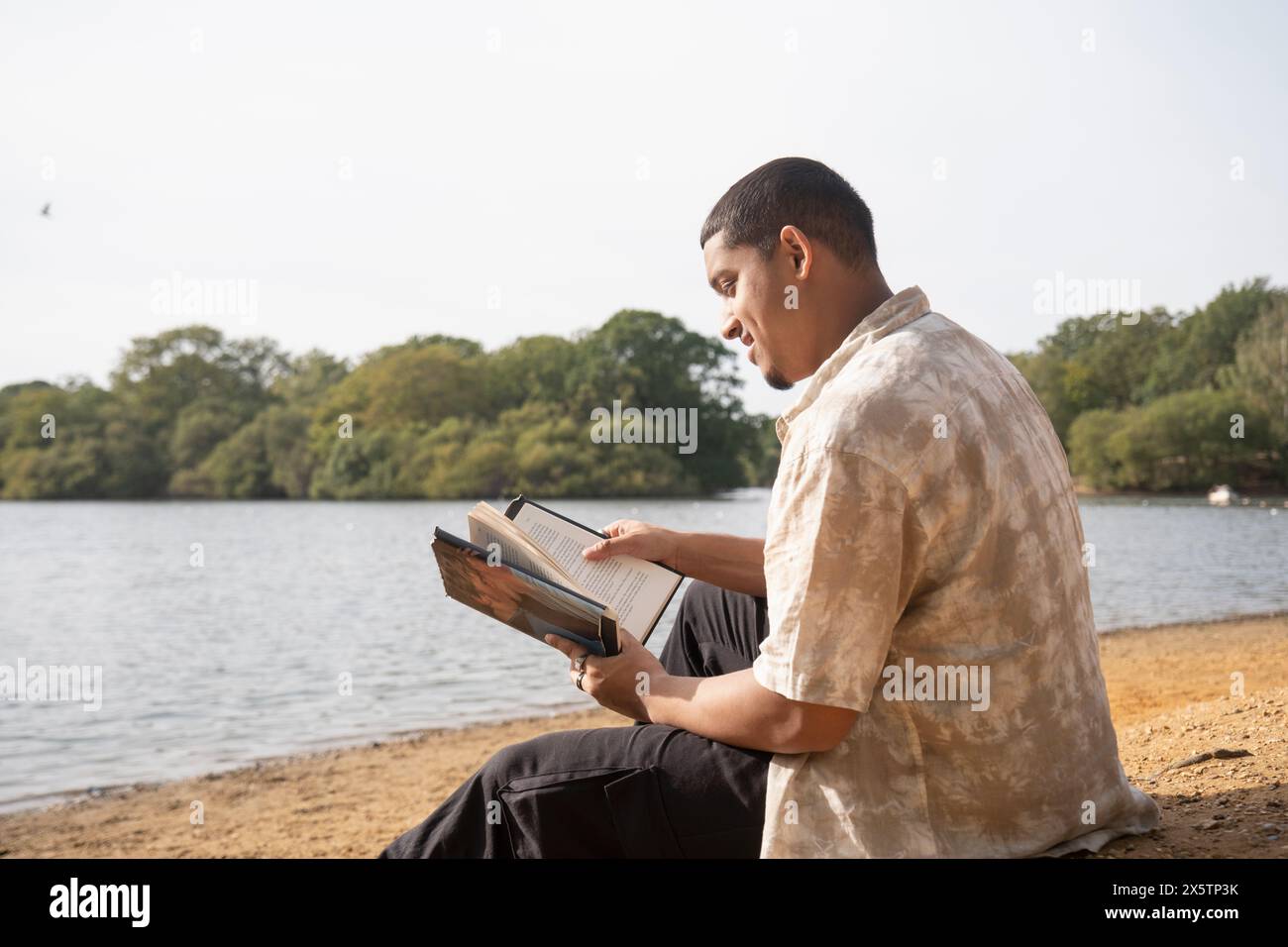 Man sitting outdoors reading book hi-res stock photography and images ...