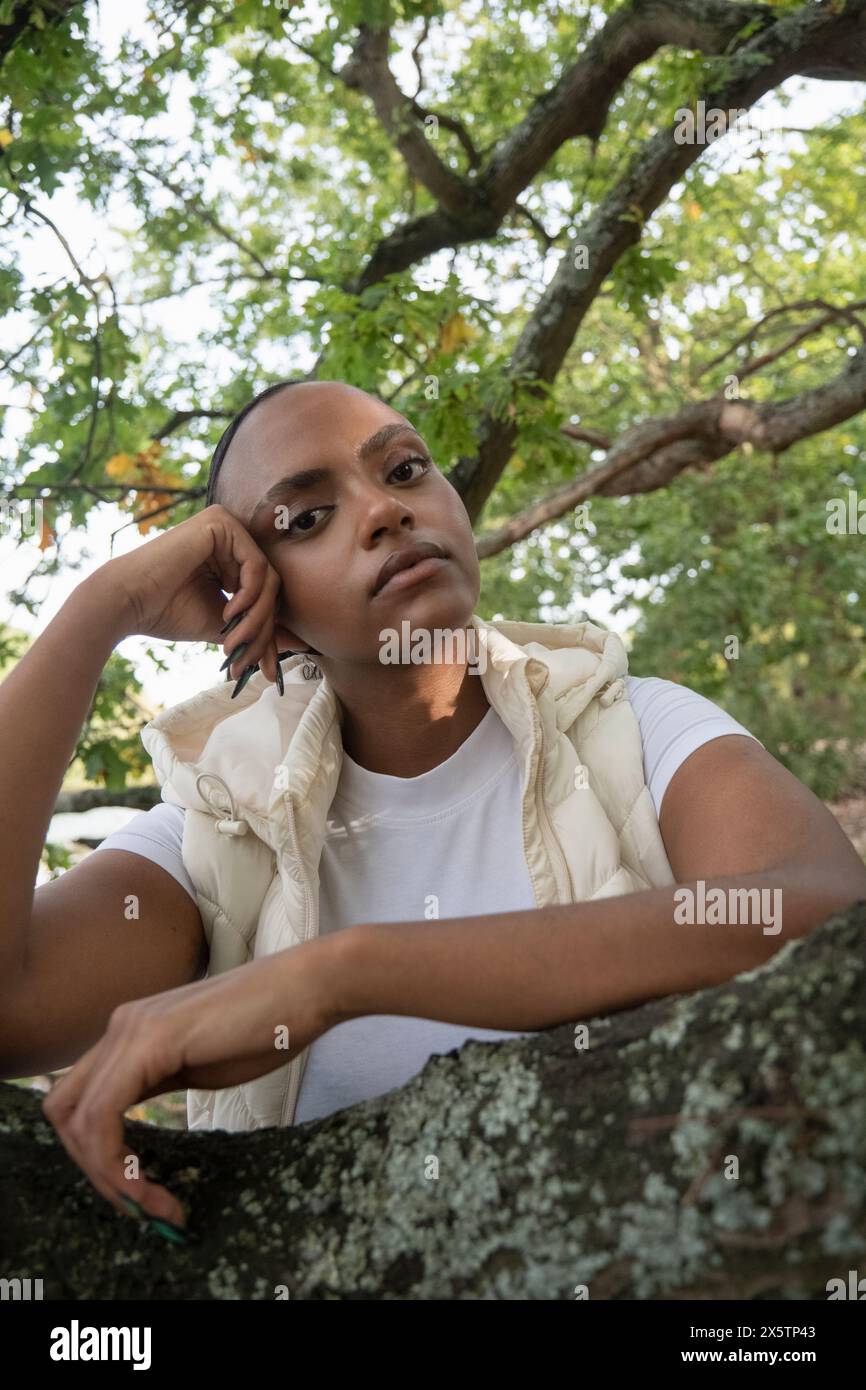 Portrait of pensive woman leaning on tree branch Stock Photo - Alamy