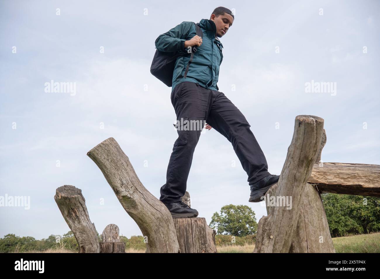Man with backpack walking on old wooden posts Stock Photo - Alamy