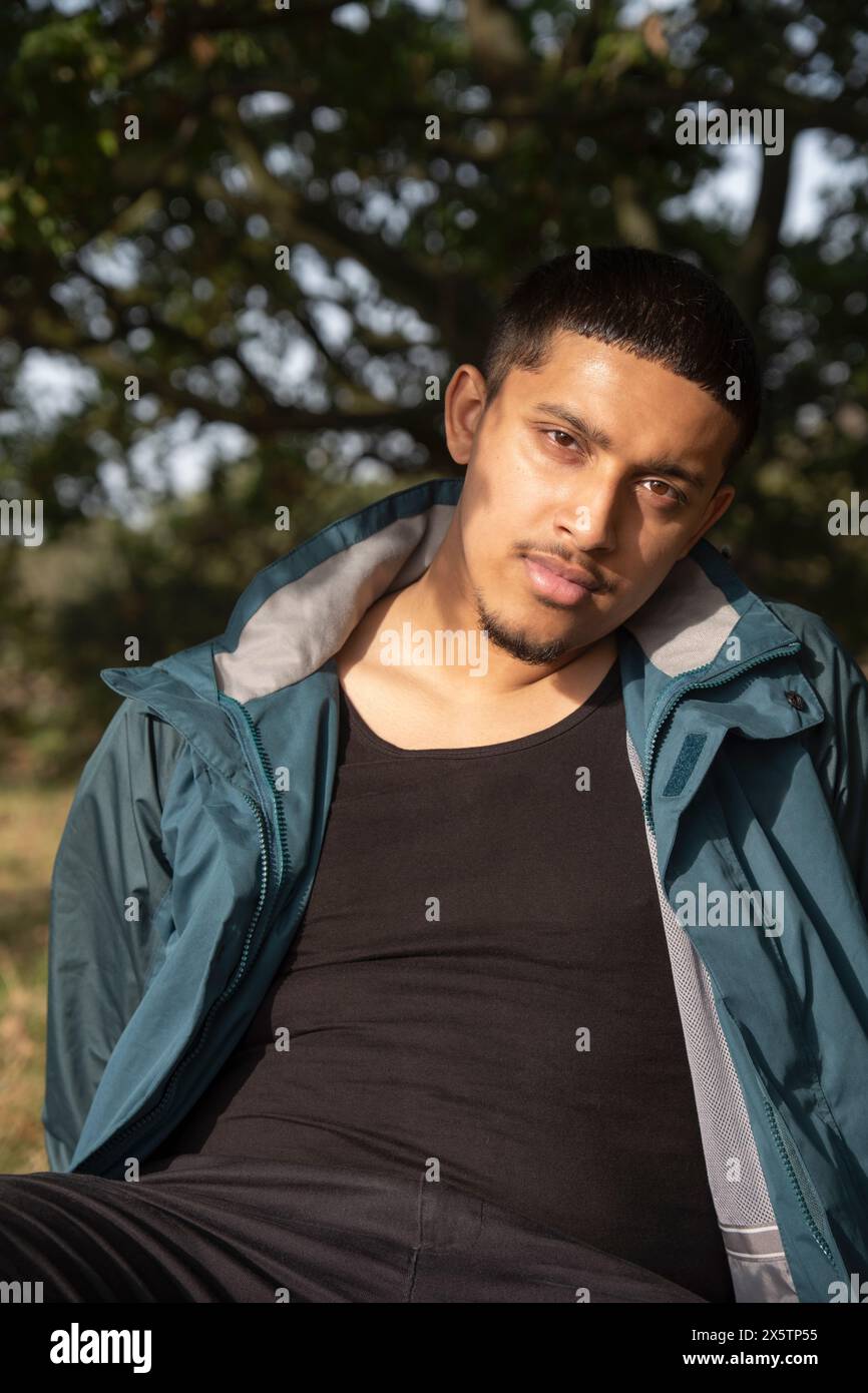 Portrait of man in jacket sitting outdoors Stock Photo - Alamy