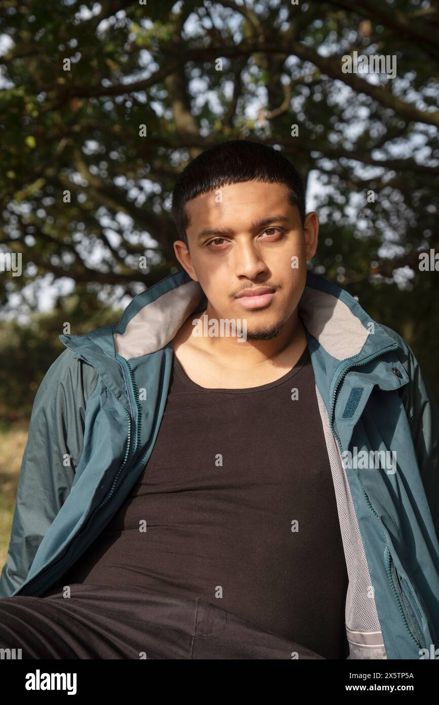 Portrait of man in jacket sitting outdoors Stock Photo - Alamy