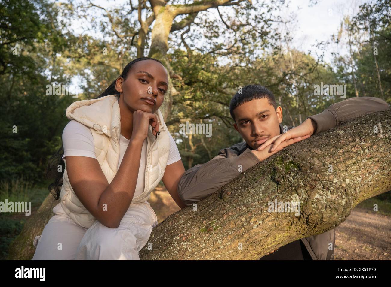 Portrait of couple leaning on tree branch Stock Photo - Alamy