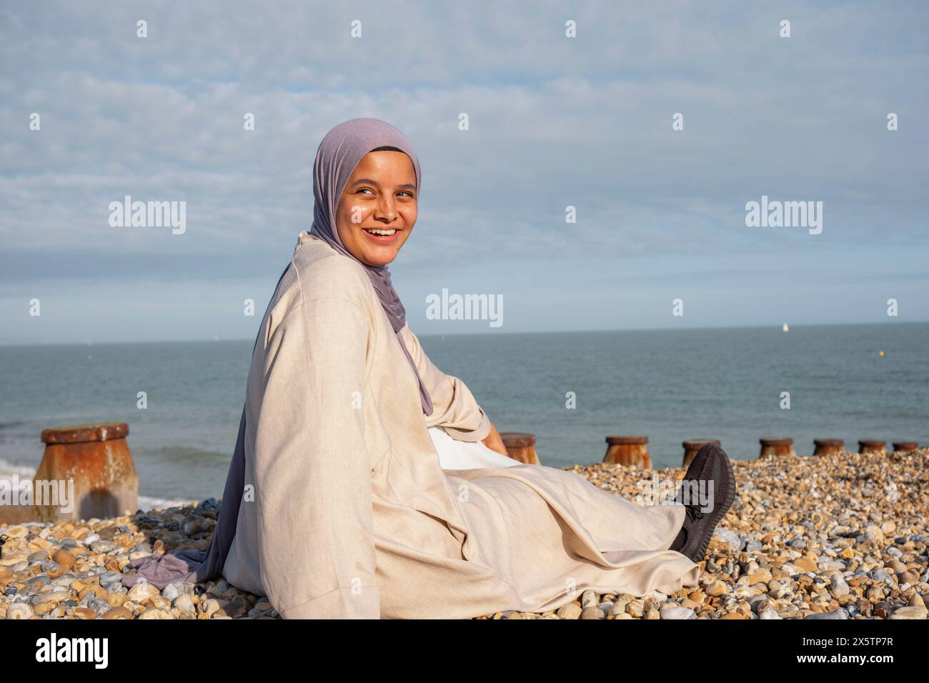 Portrait of Muslim woman sitting on beach Stock Photo - Alamy