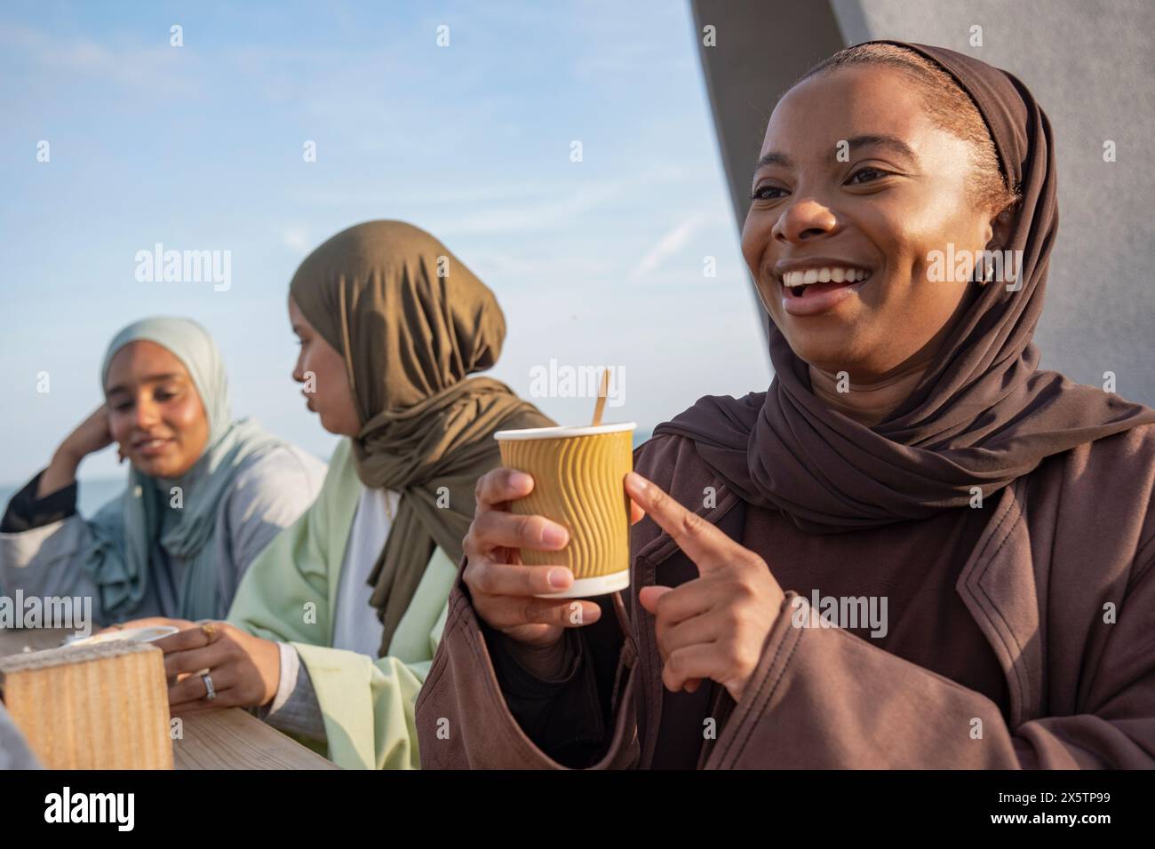 Three Muslim women drinking coffee in sidewalk cafe Stock Photo - Alamy
