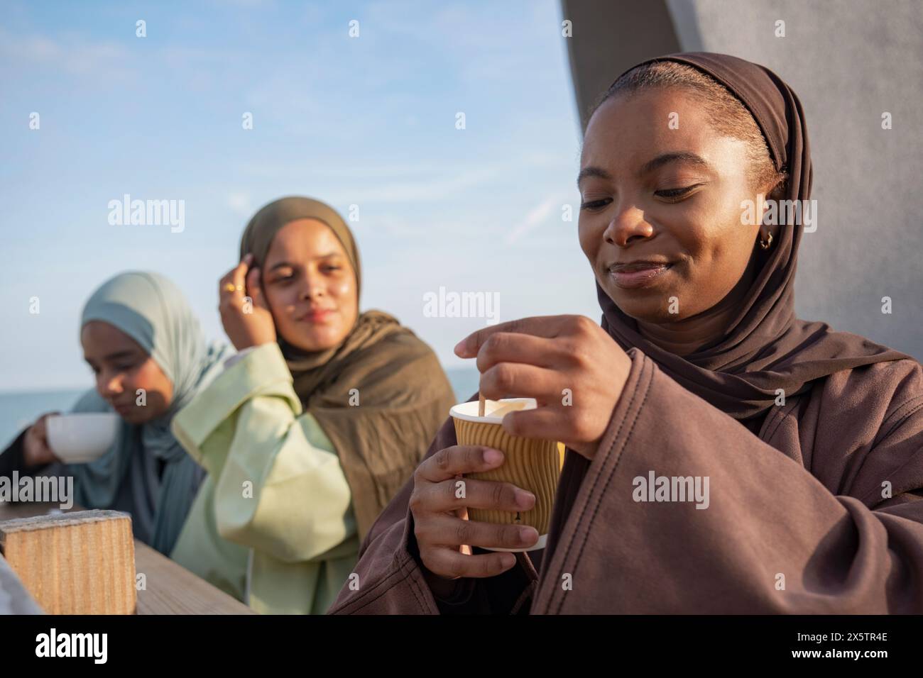Three Muslim women drinking coffee in sidewalk cafe Stock Photo - Alamy