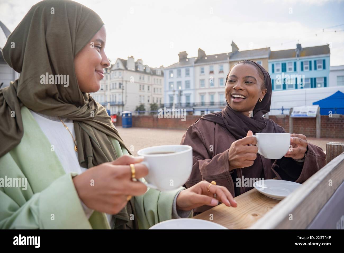 Two Muslim women drinking coffee in sidewalk cafe Stock Photo - Alamy