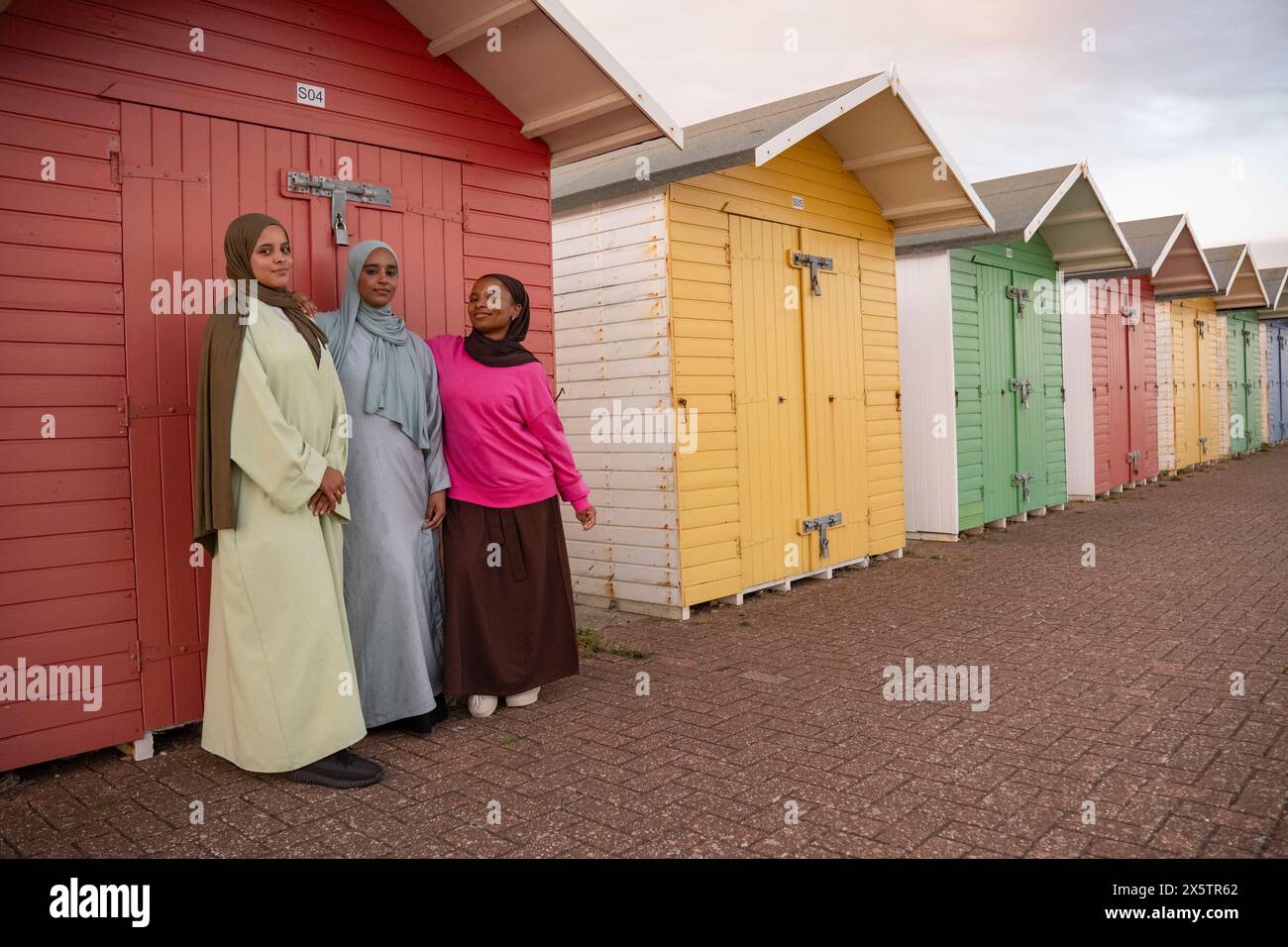 Three Muslim friends standing in front of beach hut Stock Photo - Alamy