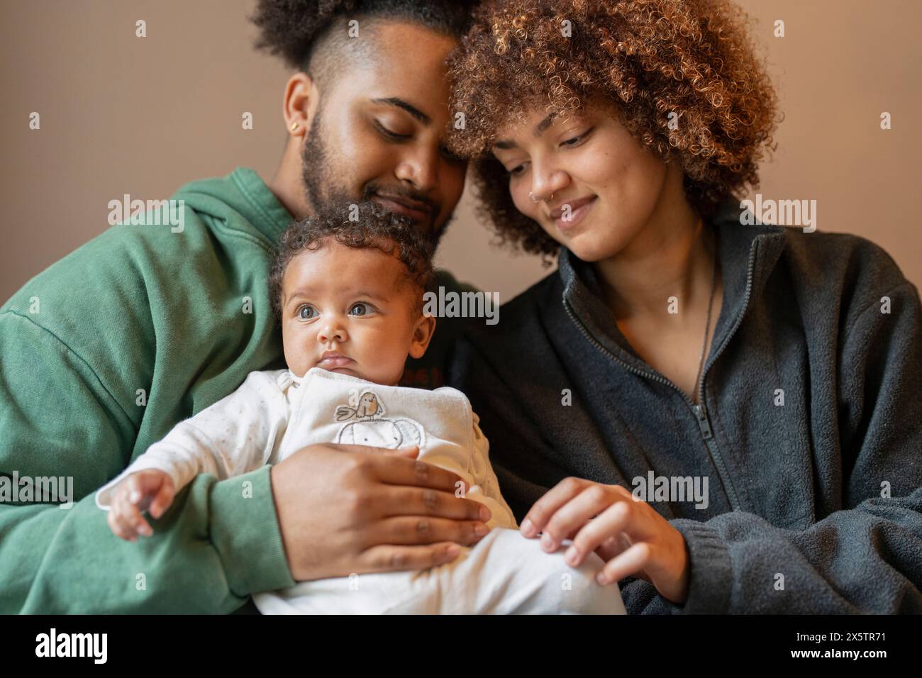 Parents sitting with baby daughter at home Stock Photo - Alamy