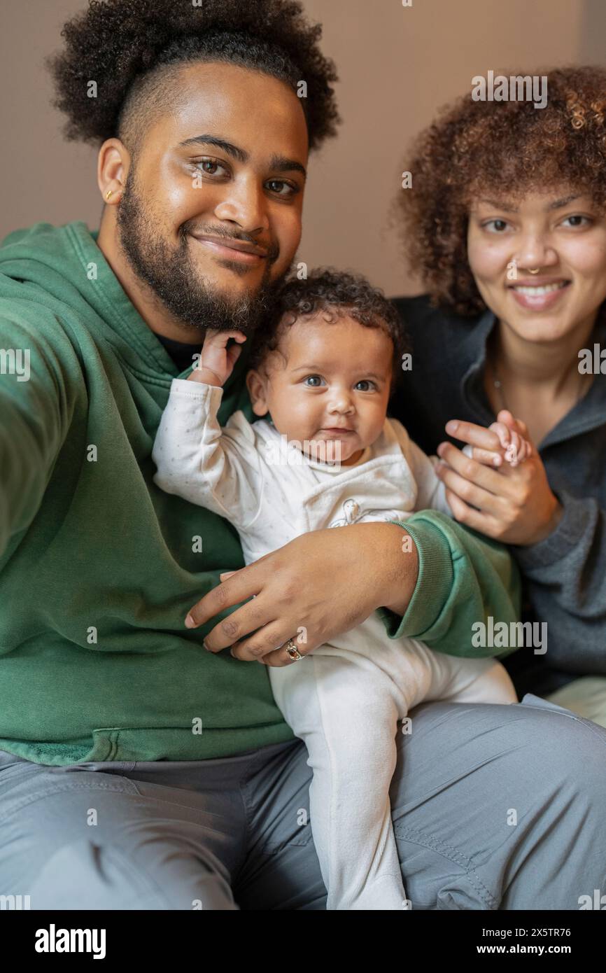 Smiling parents with baby daughter at home Stock Photo - Alamy