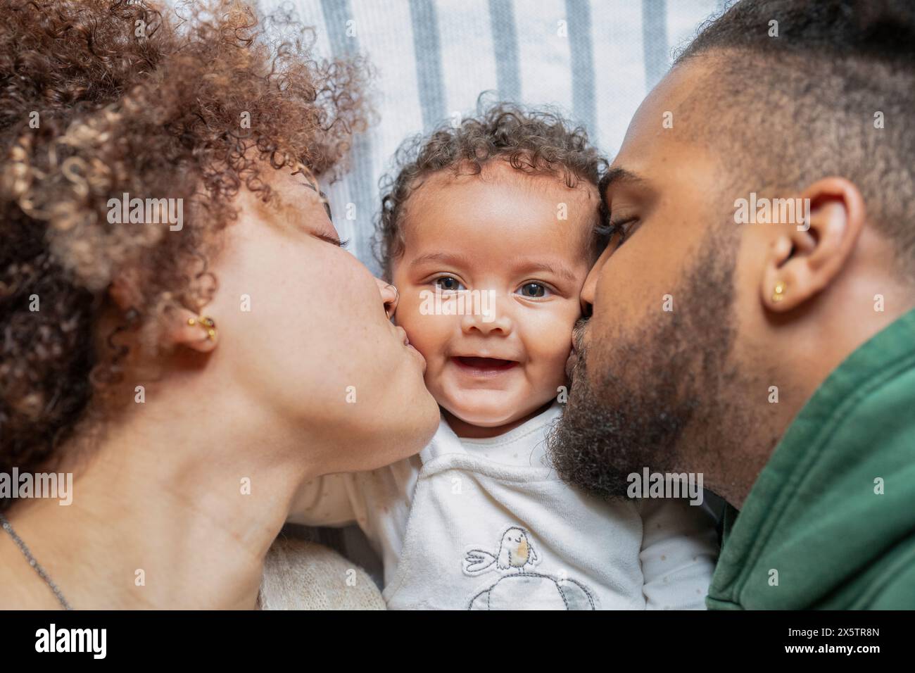 Parents kissing baby daughter Stock Photo - Alamy