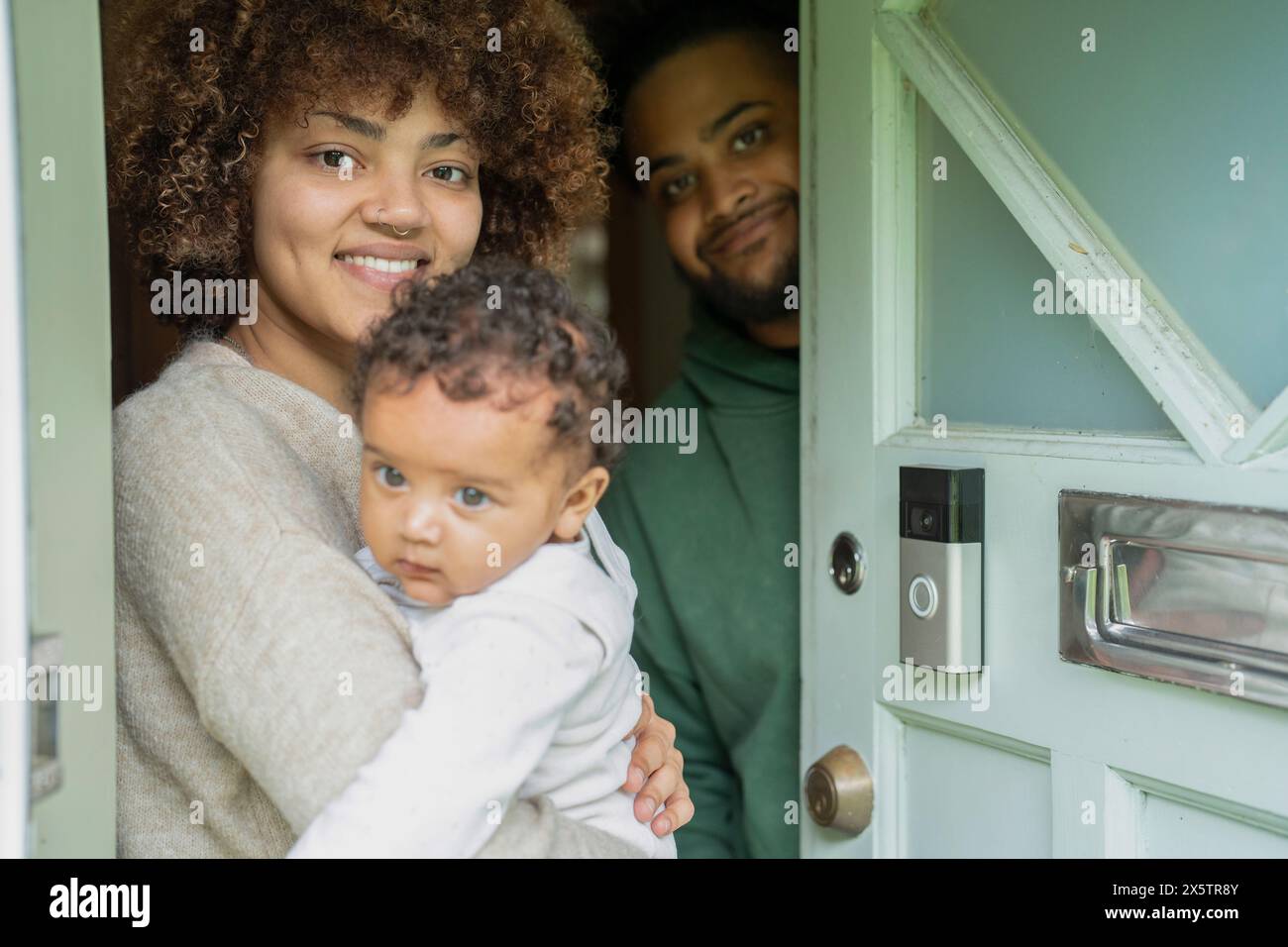 Parents with baby daughter at home entrance Stock Photo - Alamy