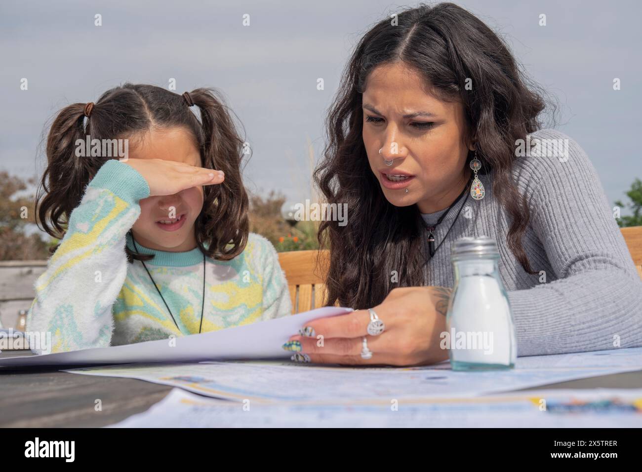 Mother with daughter reading menu in outdoor restaurant Stock Photo - Alamy