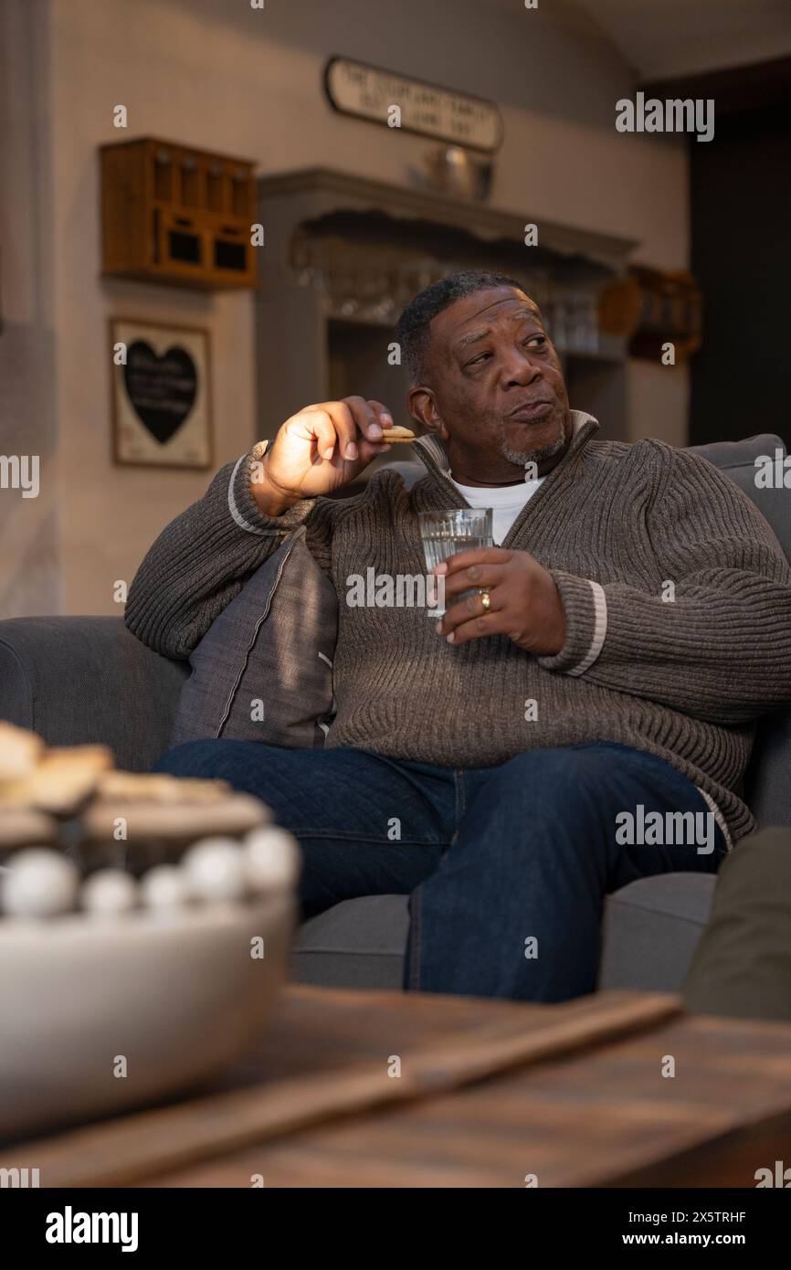 Man sitting home on sofa hi-res stock photography and images - Alamy