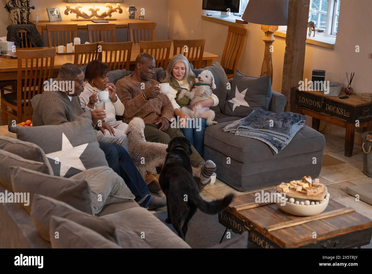Friends relaxing on sofa at home Stock Photo - Alamy