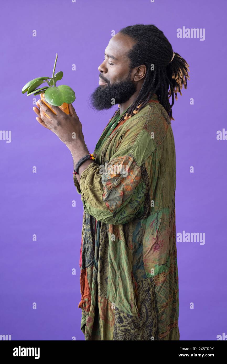 Side view of man holding potted plant Stock Photo - Alamy