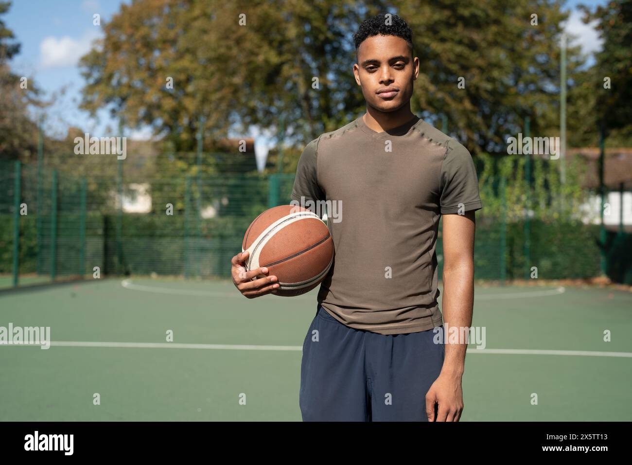 Portrait of man with basketball ball in basketball court Stock Photo ...