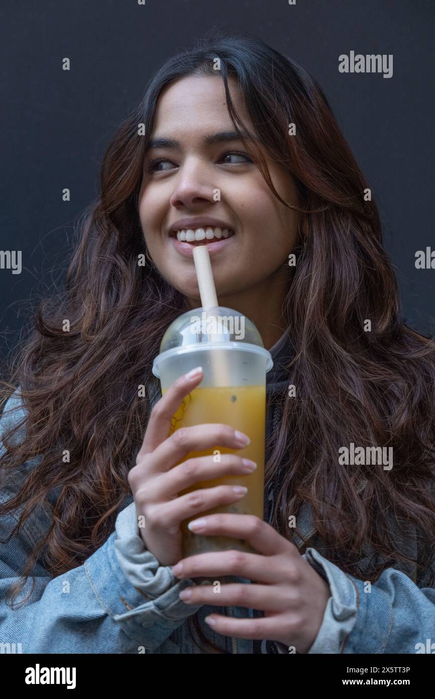 Portrait of cheerful young woman drinking bubble tea Stock Photo - Alamy