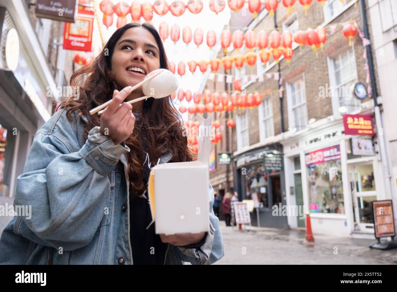 Young woman eating steamed bun in Chinatown Stock Photo - Alamy