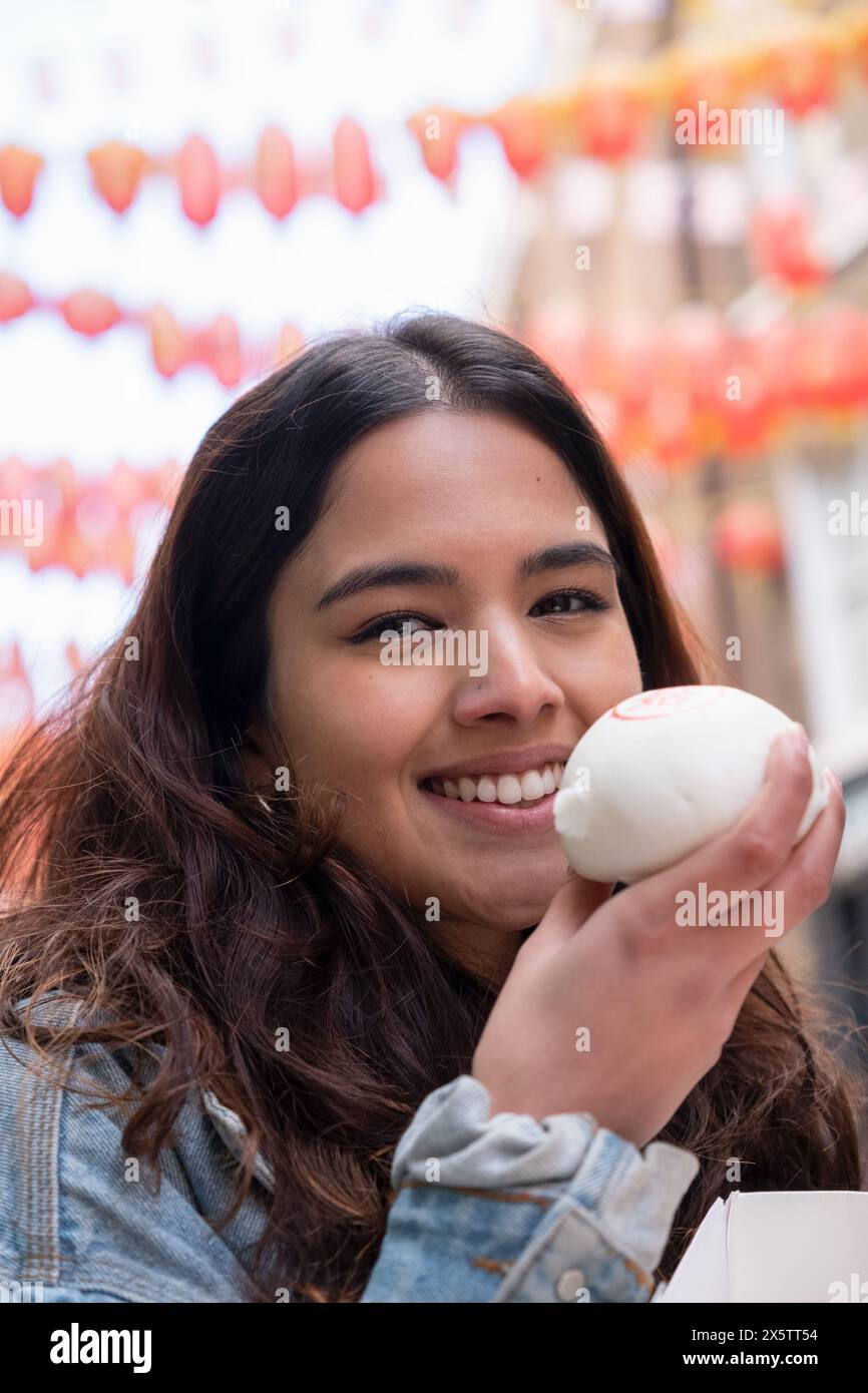 Young woman eating steamed bun in Chinatown Stock Photo - Alamy