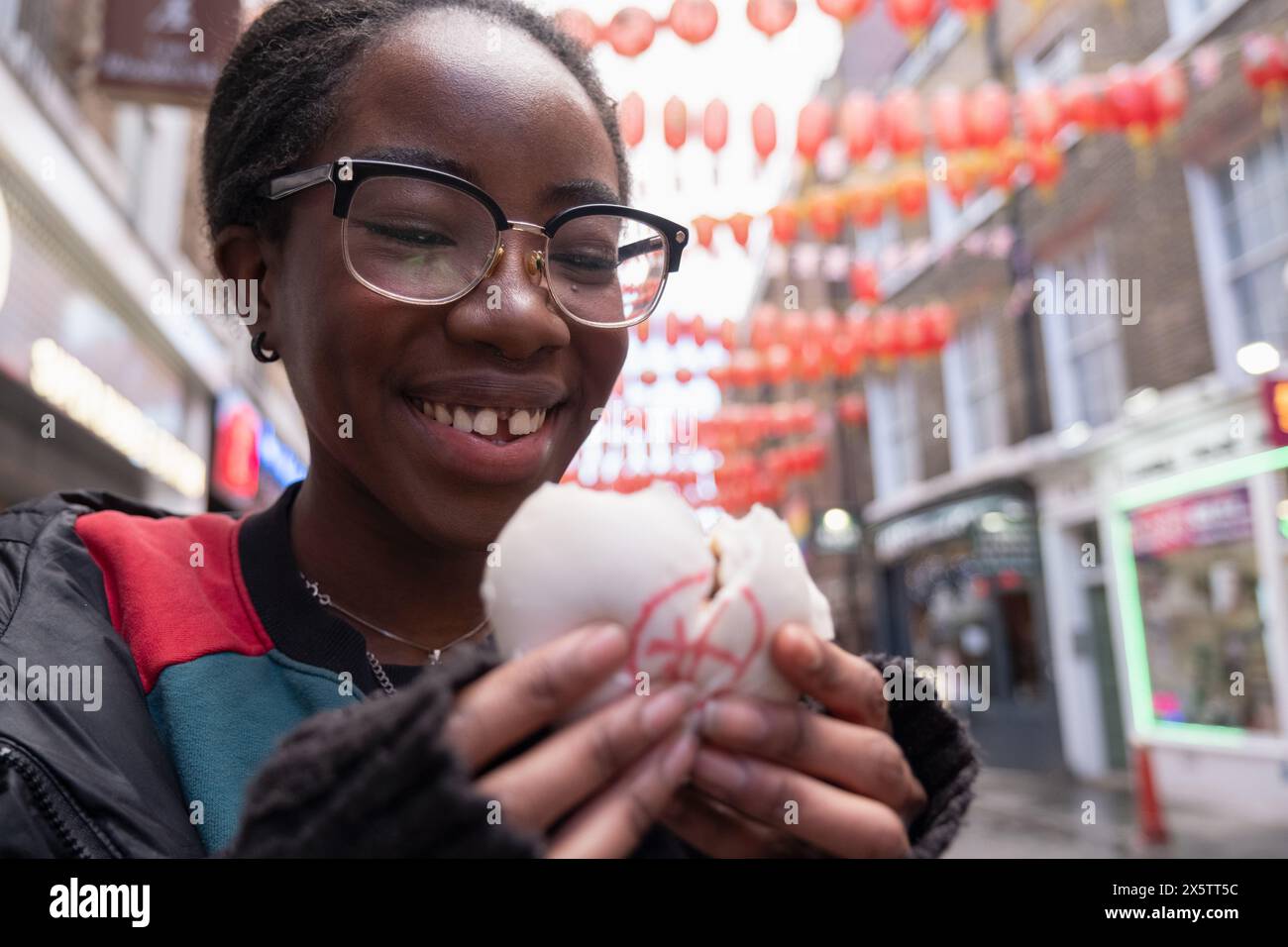 Young woman eating steamed bun in Chinatown Stock Photo - Alamy