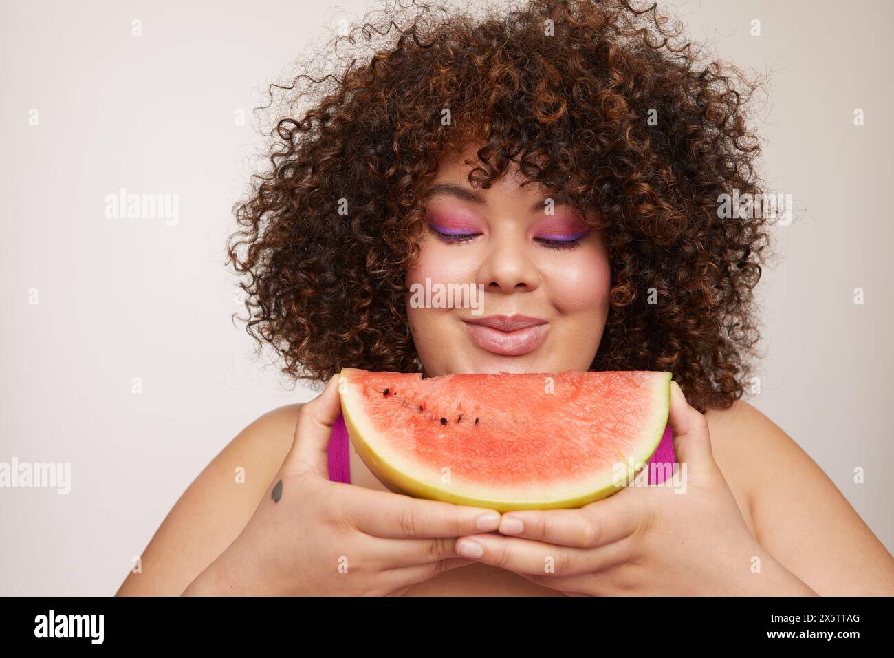 Brunette woman holding slice of watermelon Stock Photo - Alamy