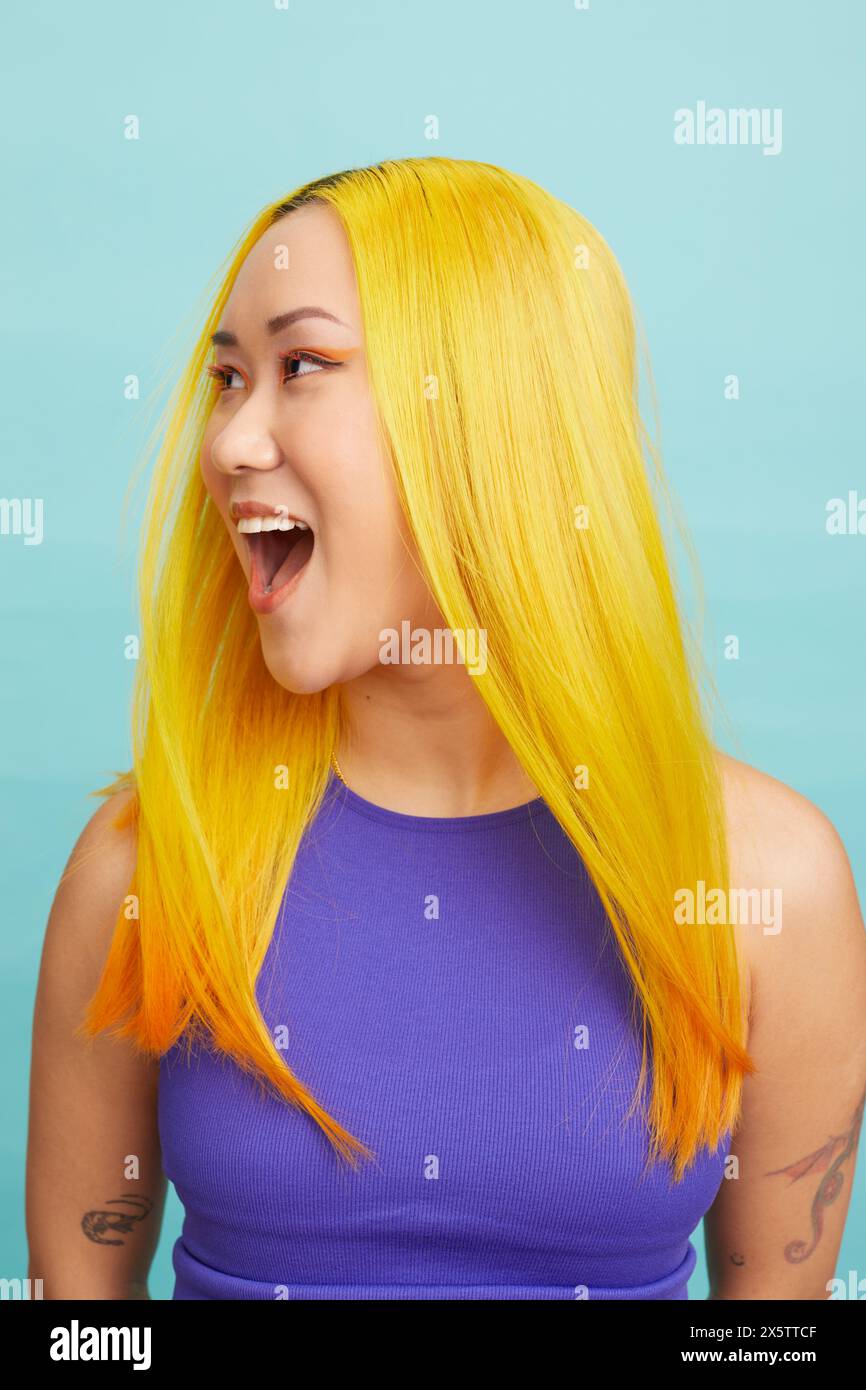 Young woman with long yellow hair and open mouth, looking away Stock ...