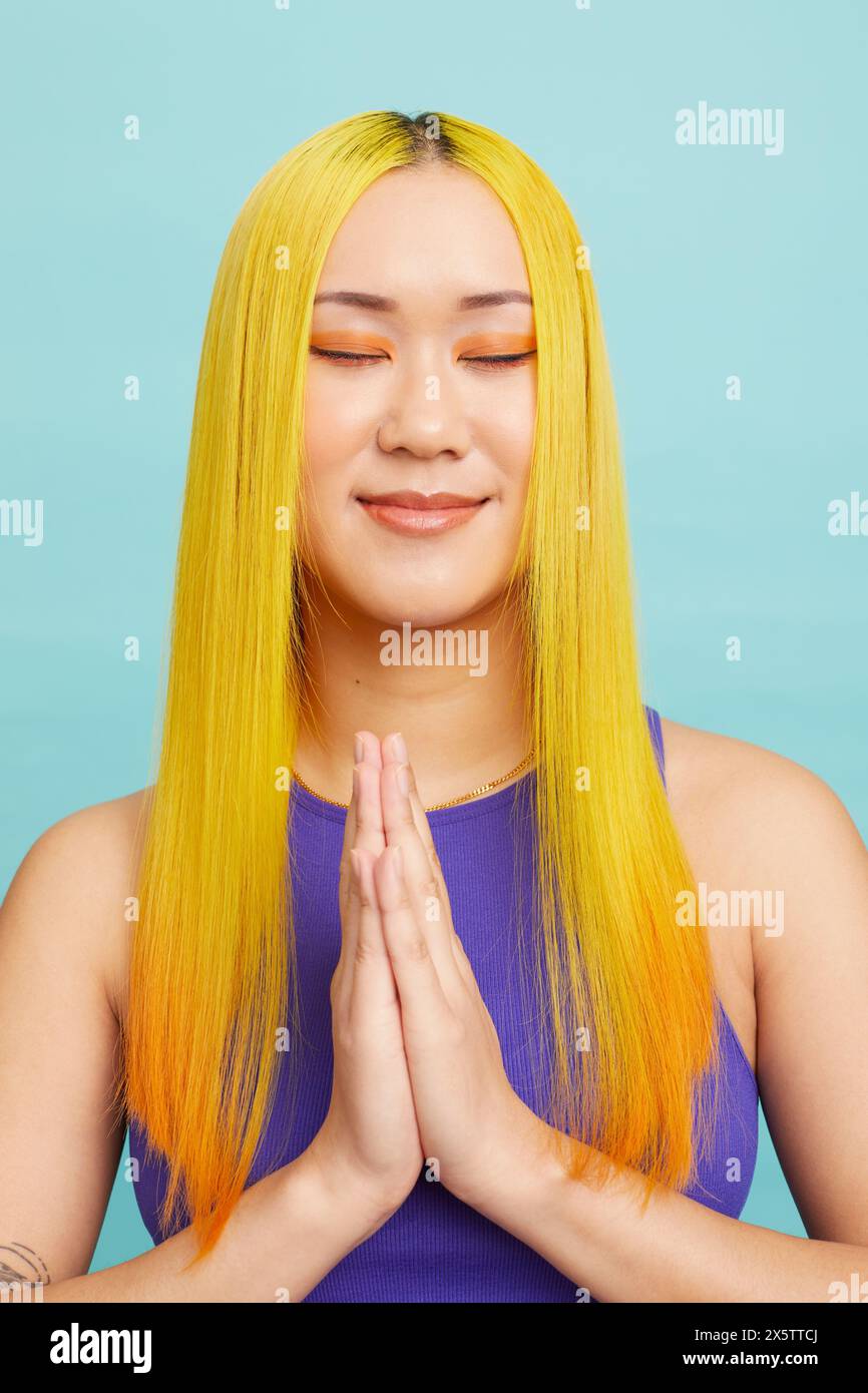 Young woman with long yellow hair, closed eyes and clasped hands Stock ...
