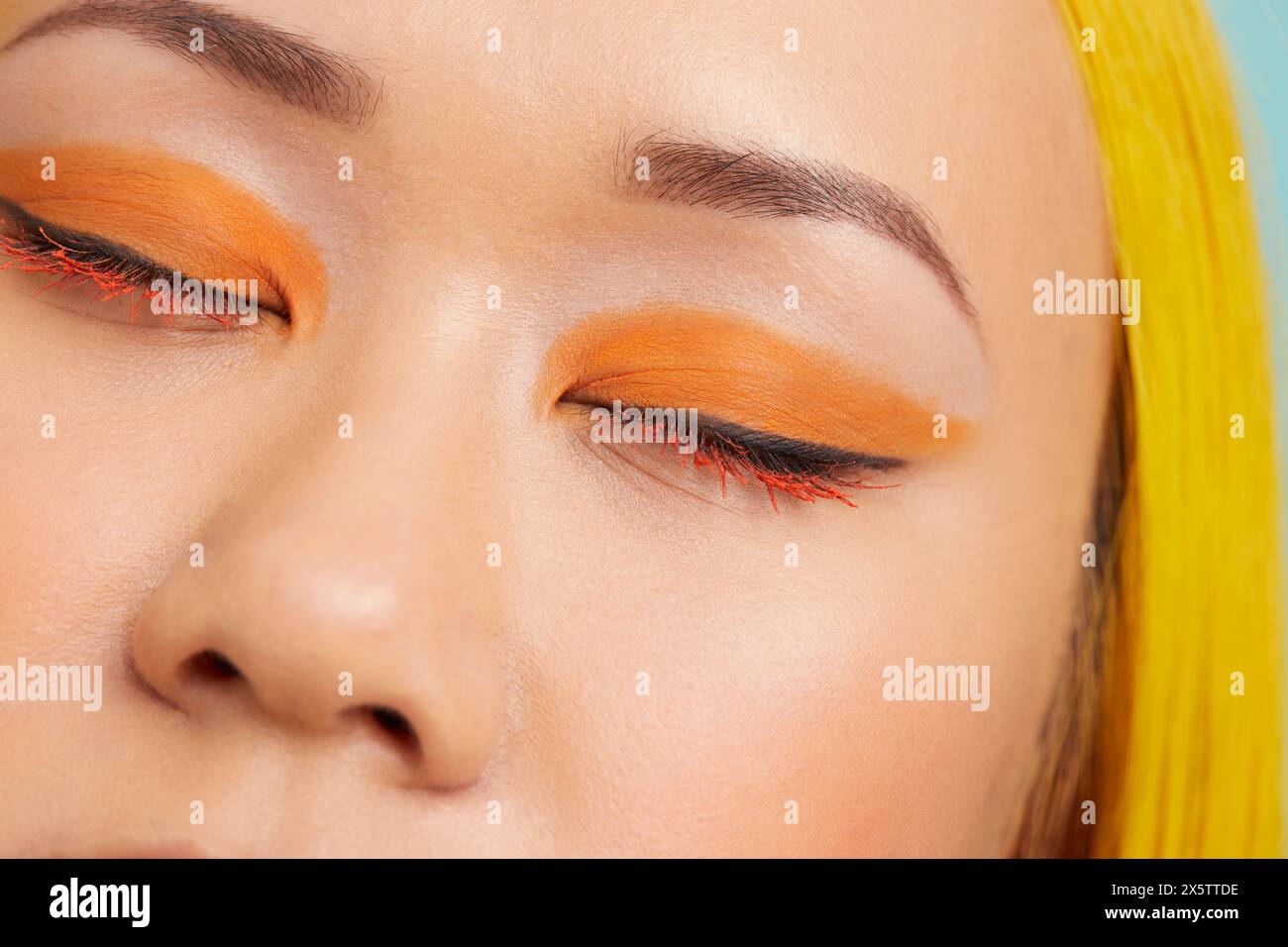 Young woman with orange make up, eyes closed Stock Photo - Alamy