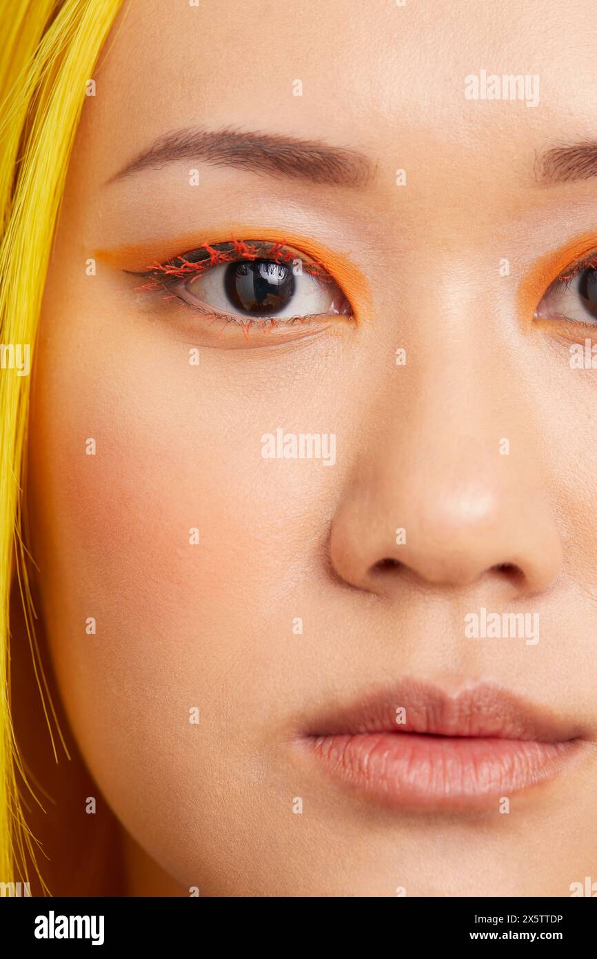 Portrait of woman wearing orange make up Stock Photo - Alamy