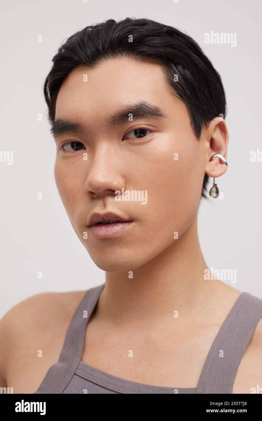 Studio portrait of handsome man with ear piercing Stock Photo - Alamy