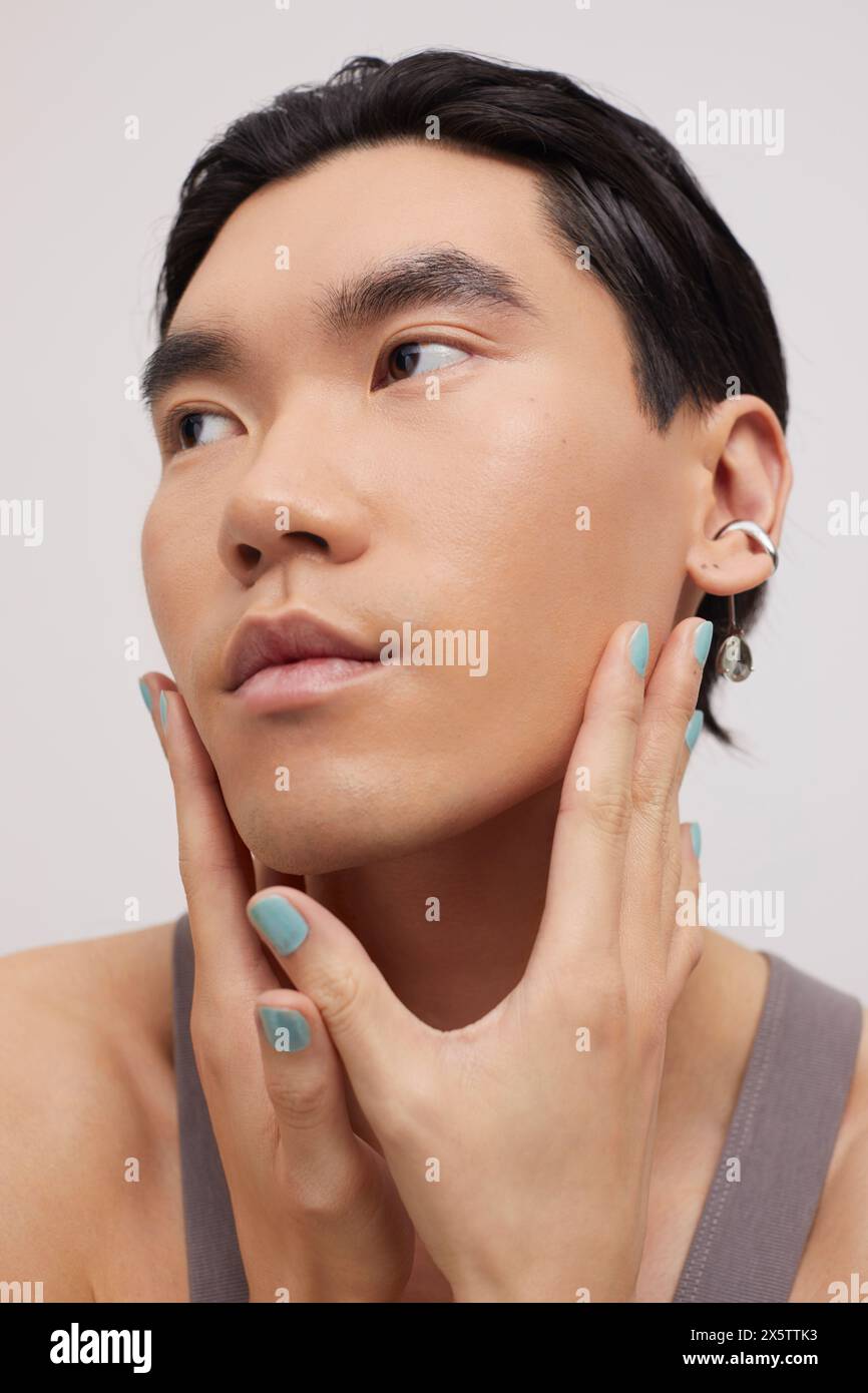 Studio portrait of handsome man with ear piercing Stock Photo - Alamy