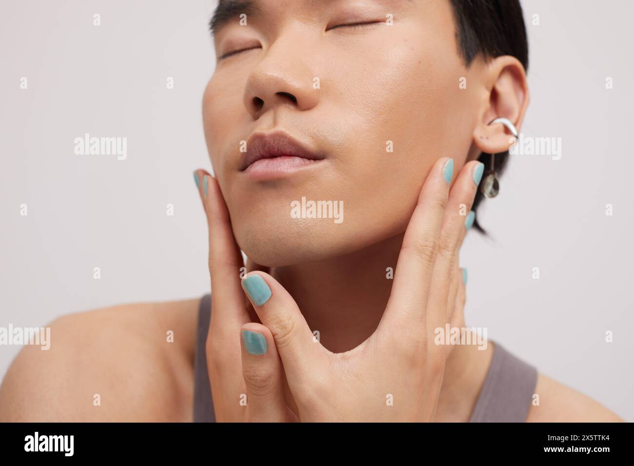 Studio portrait of handsome man with ear piercing Stock Photo - Alamy