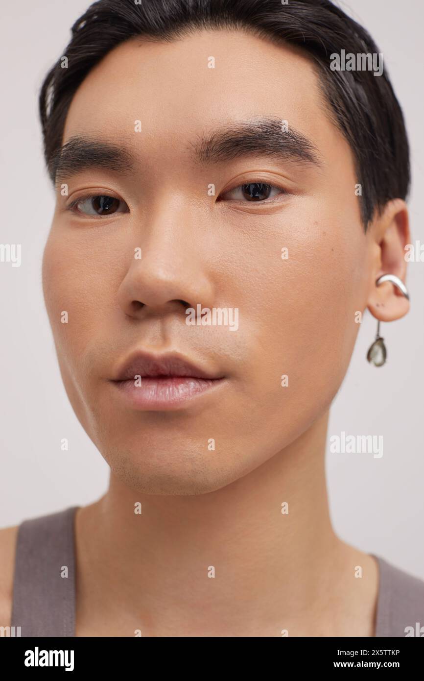 Studio portrait of handsome man with ear piercing Stock Photo - Alamy