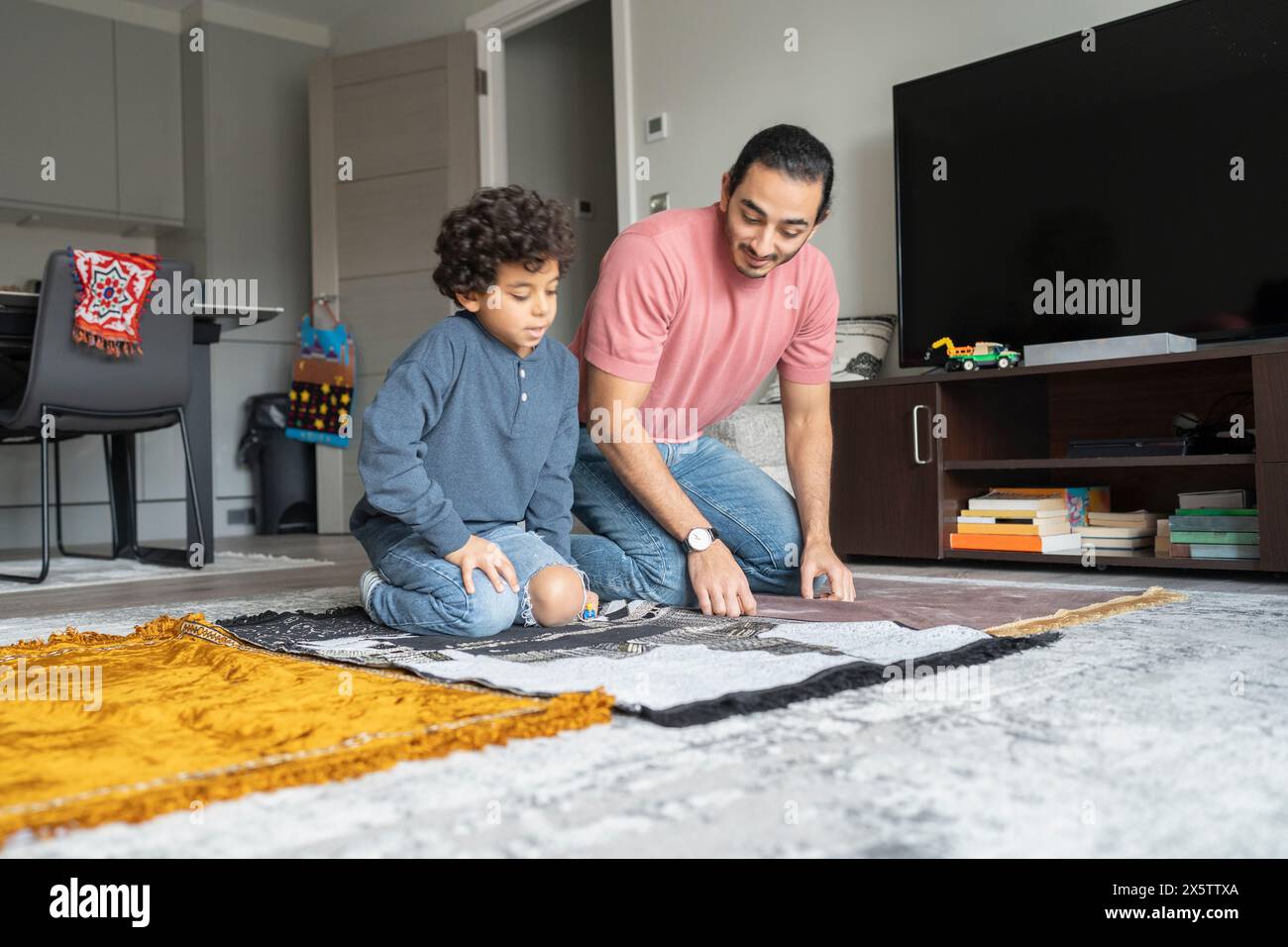 Father and son (6-7) praying at home Stock Photo - Alamy