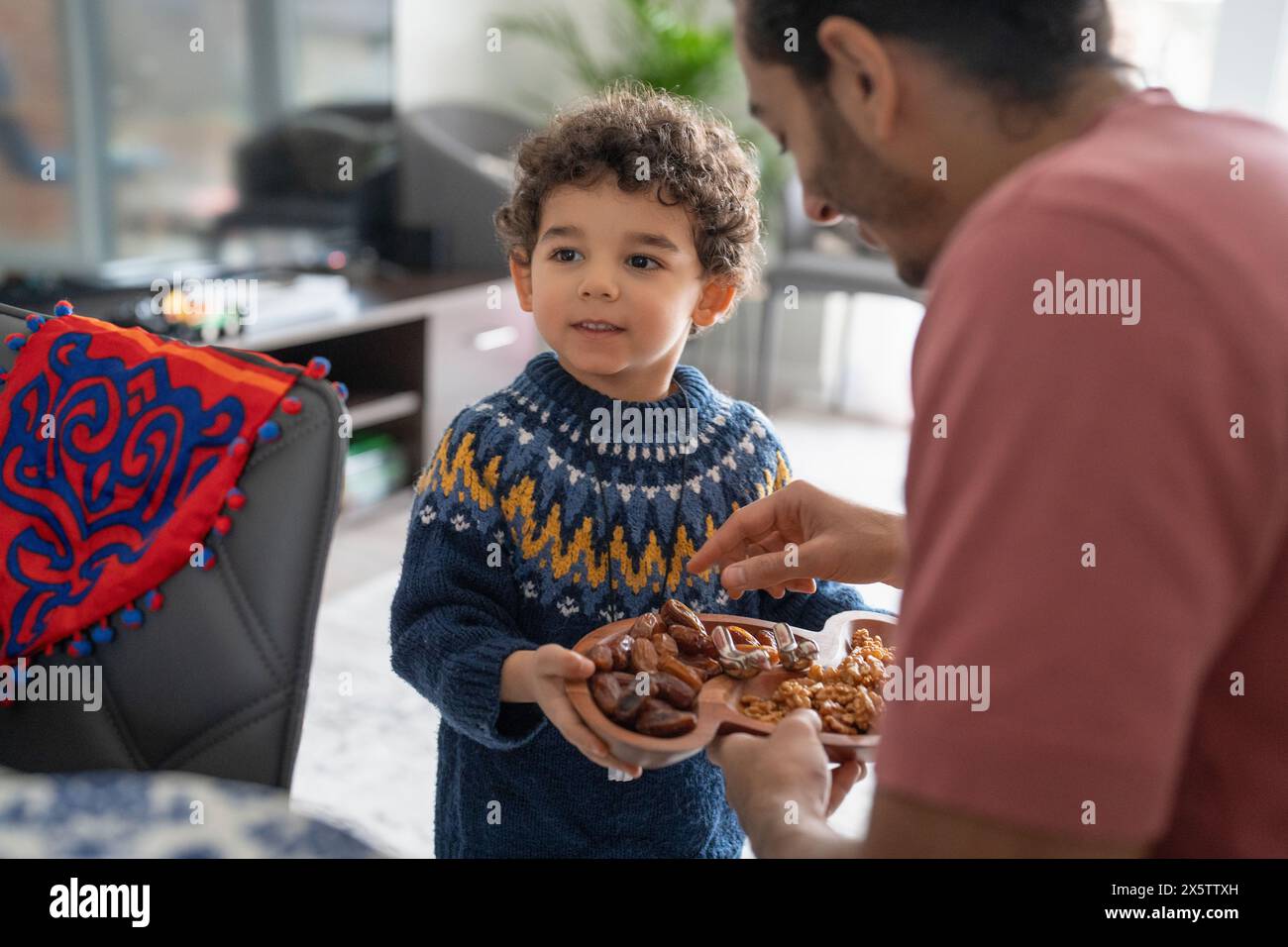 Father and son (2-3) eating dates at home Stock Photo - Alamy