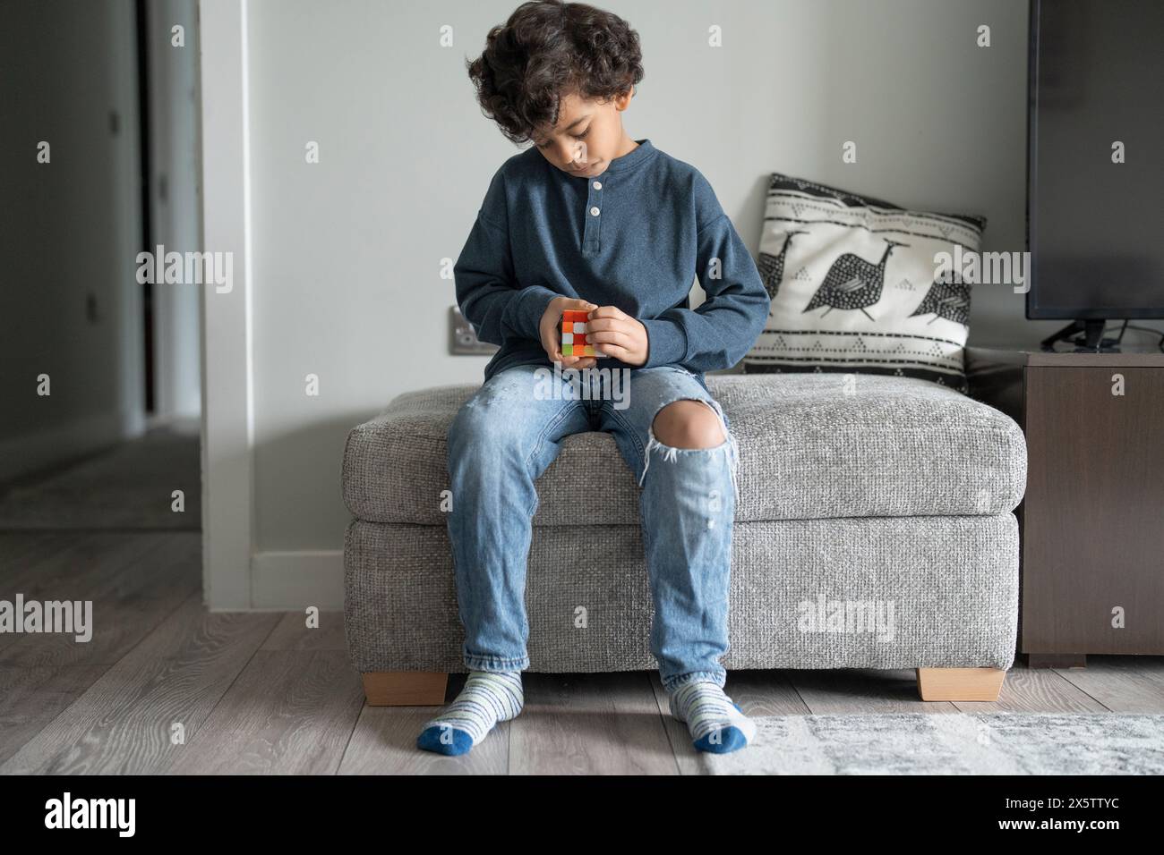 Boy (6-7) solving puzzle cube at home Stock Photo - Alamy