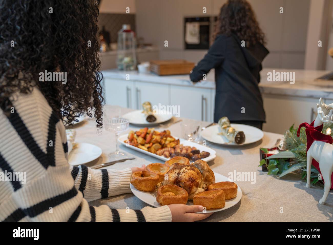 Girl serving food for Christmas dinner Stock Photo - Alamy