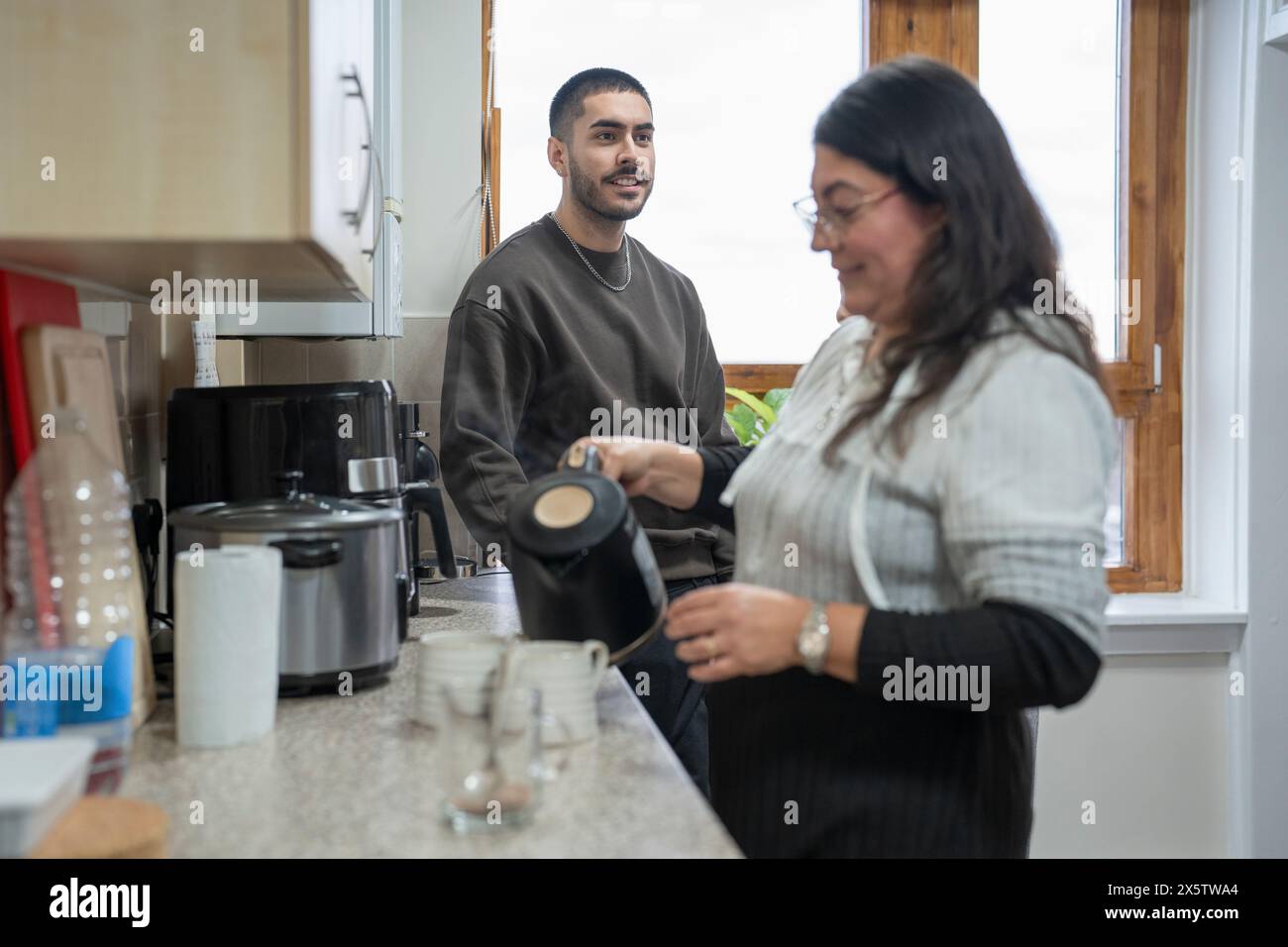 Smiling mother and son preparing tea at home Stock Photo - Alamy