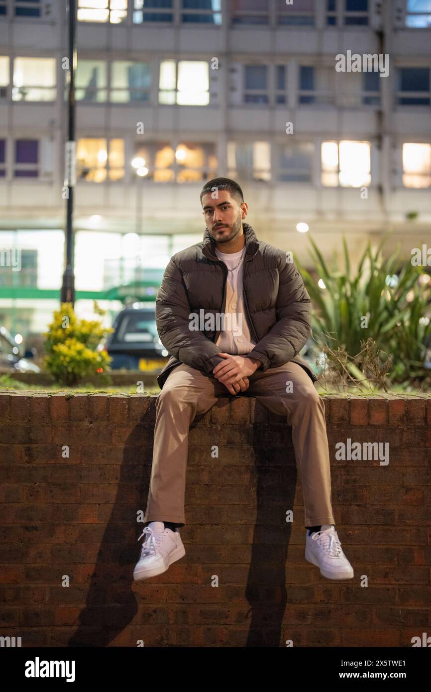Man sitting wall hi-res stock photography and images - Alamy
