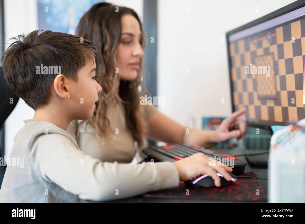 Mother and son (6-7) playing chess on computer Stock Photo - Alamy