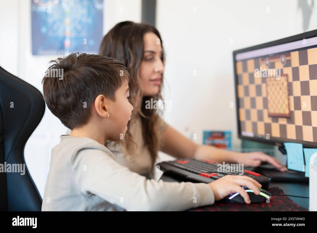 Mother and son (6-7) playing chess on computer Stock Photo - Alamy