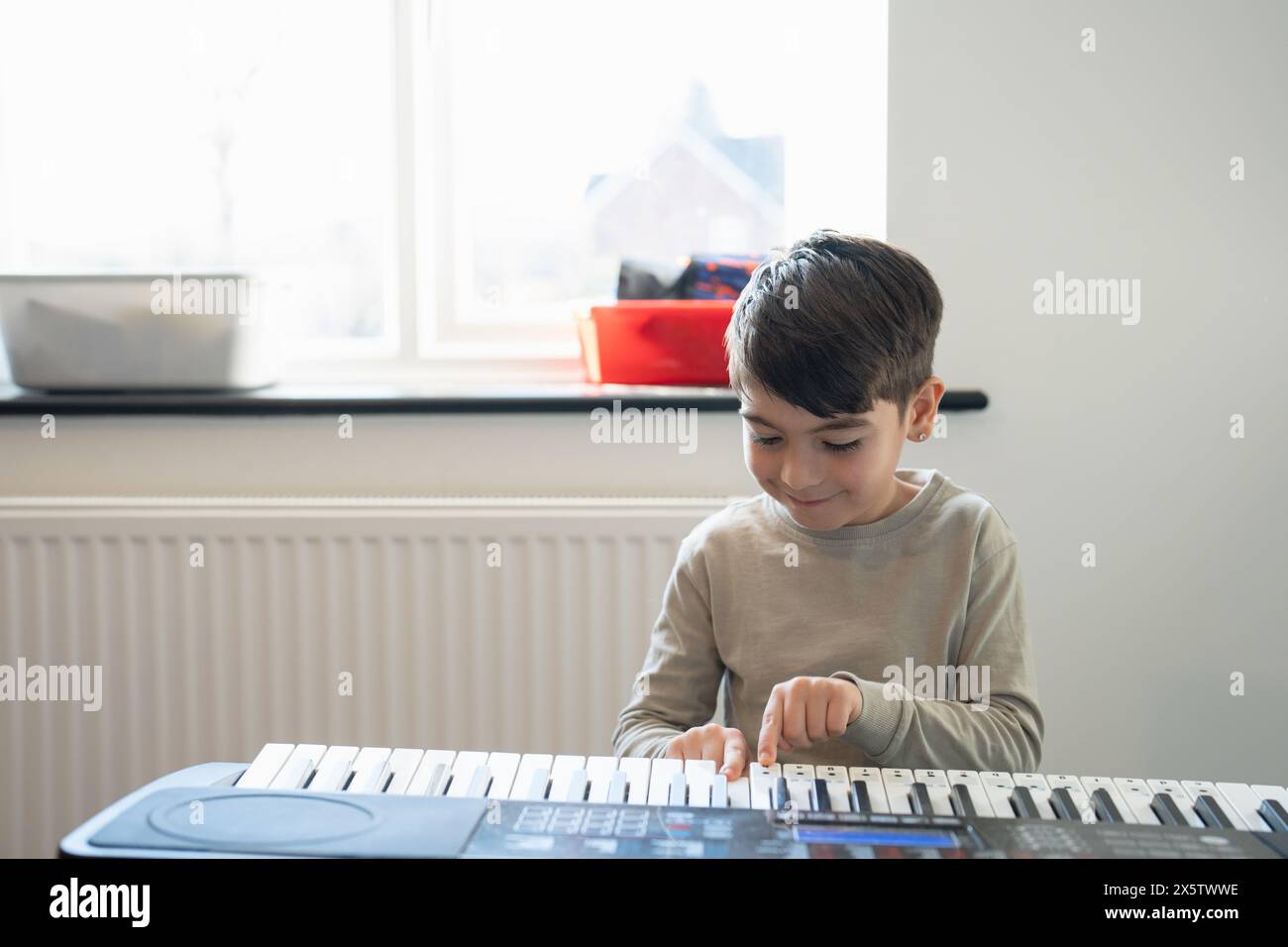 Boy (6-7) playing music keyboard at home Stock Photo - Alamy